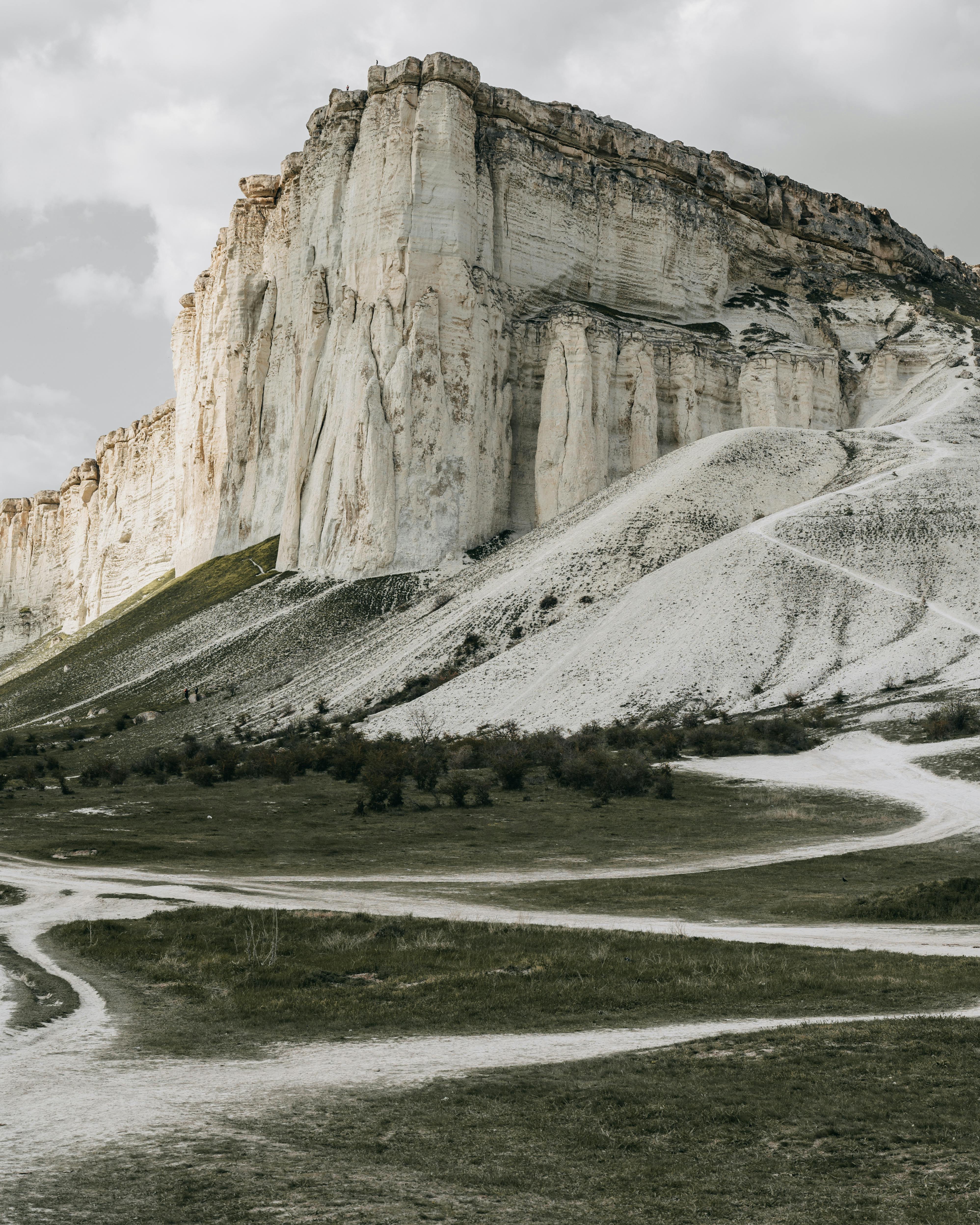 High majestic rough hill surrounded with green glades · Free Stock Photo