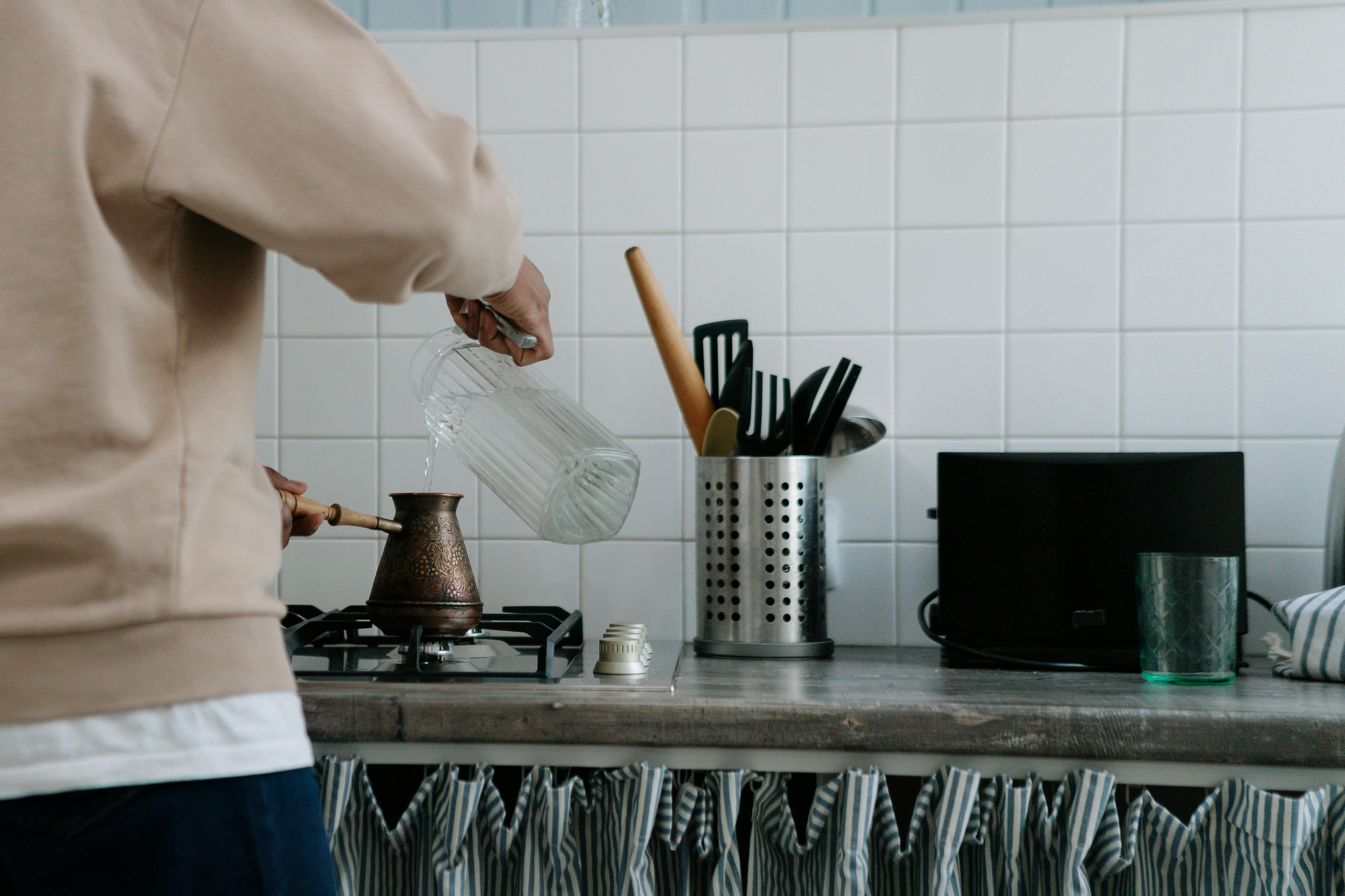 Man Making Coffee in Cezve on Stove at Home · Free Stock Photo