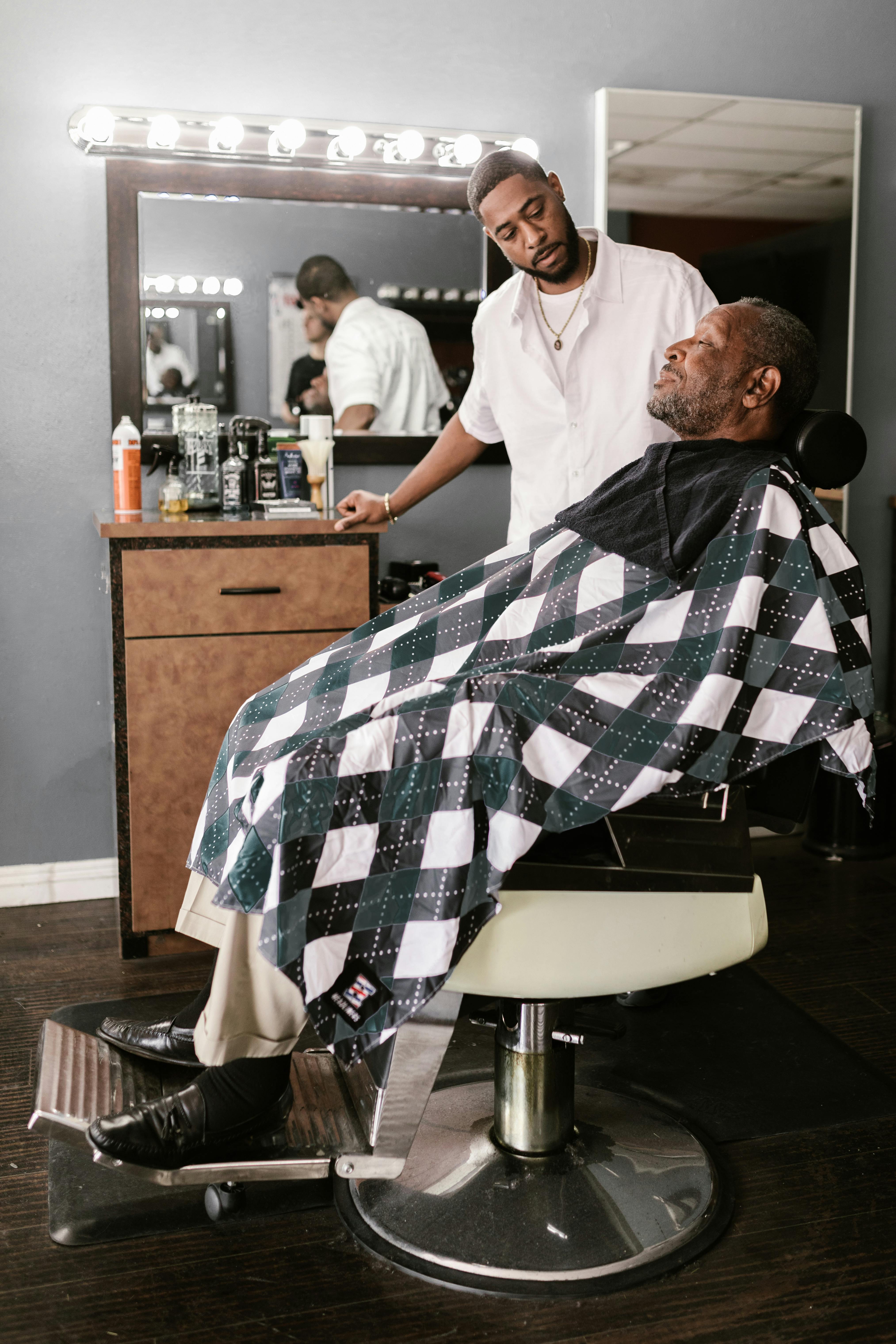 Two Black Male Friend Having A Haircut In A Barber Shop Photos ...