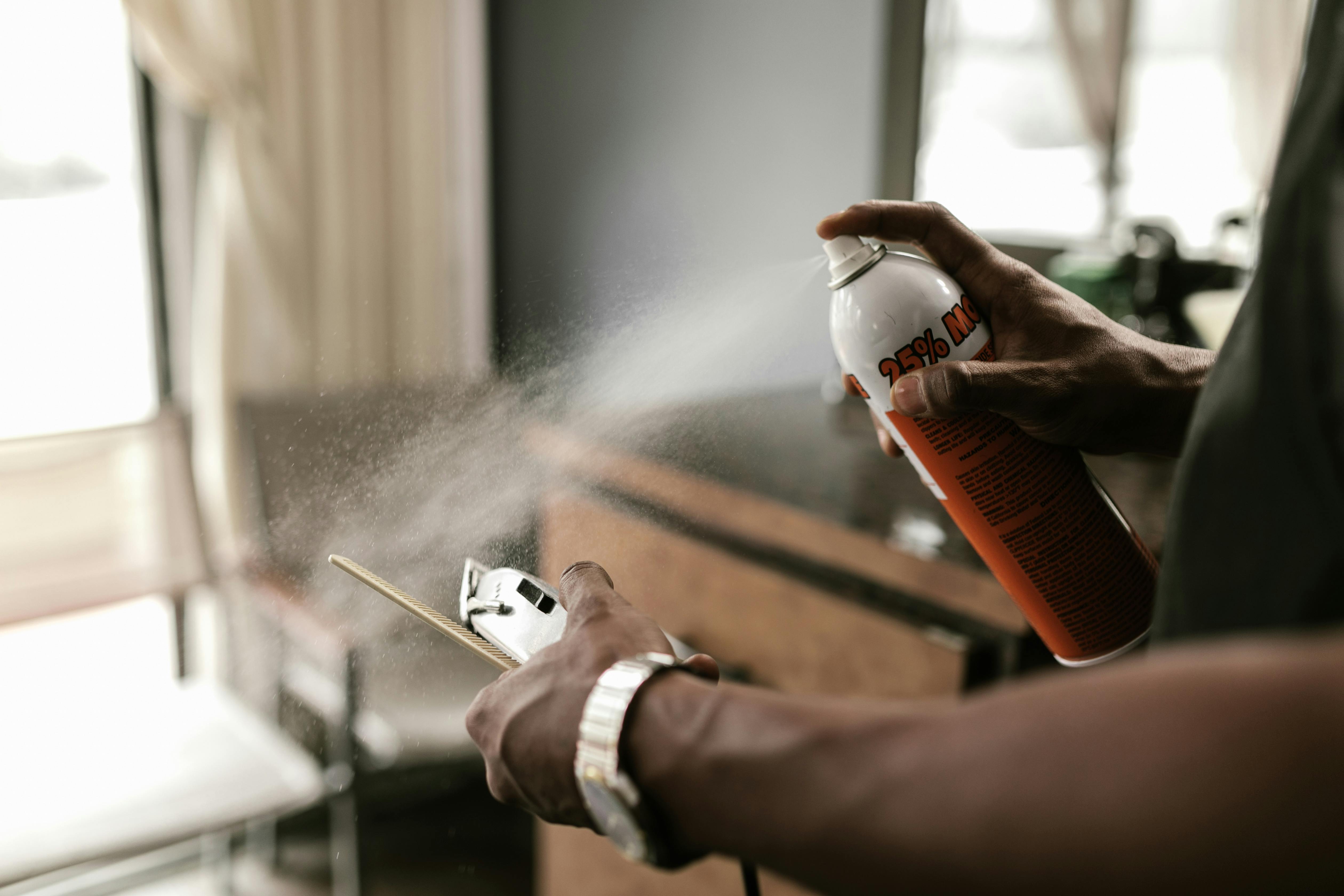 A Barber Disinfecting a Hair Clipper and Comb · Free Stock Photo