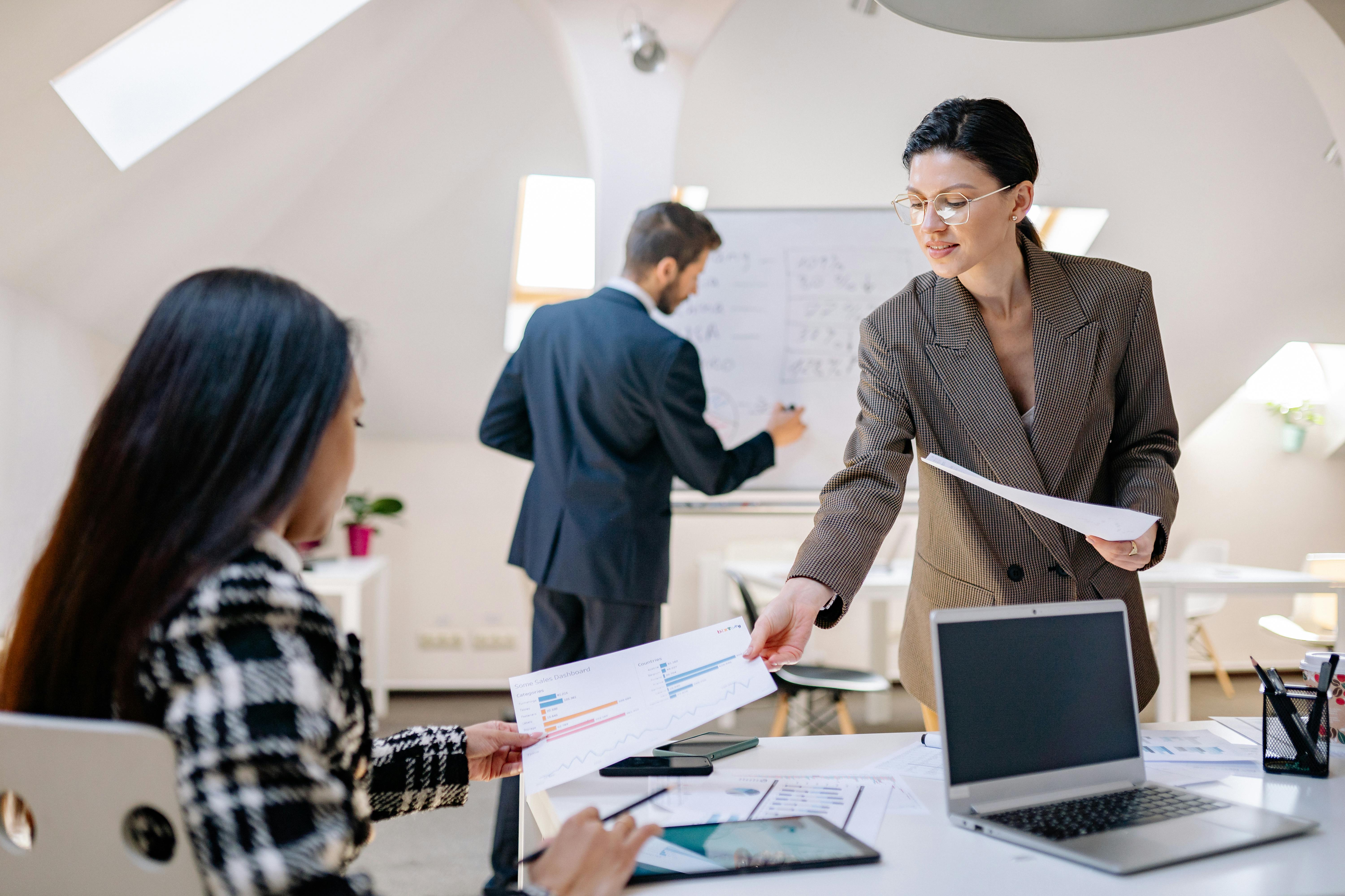 Woman Passing Paper to the Person Sitting · Free Stock Photo