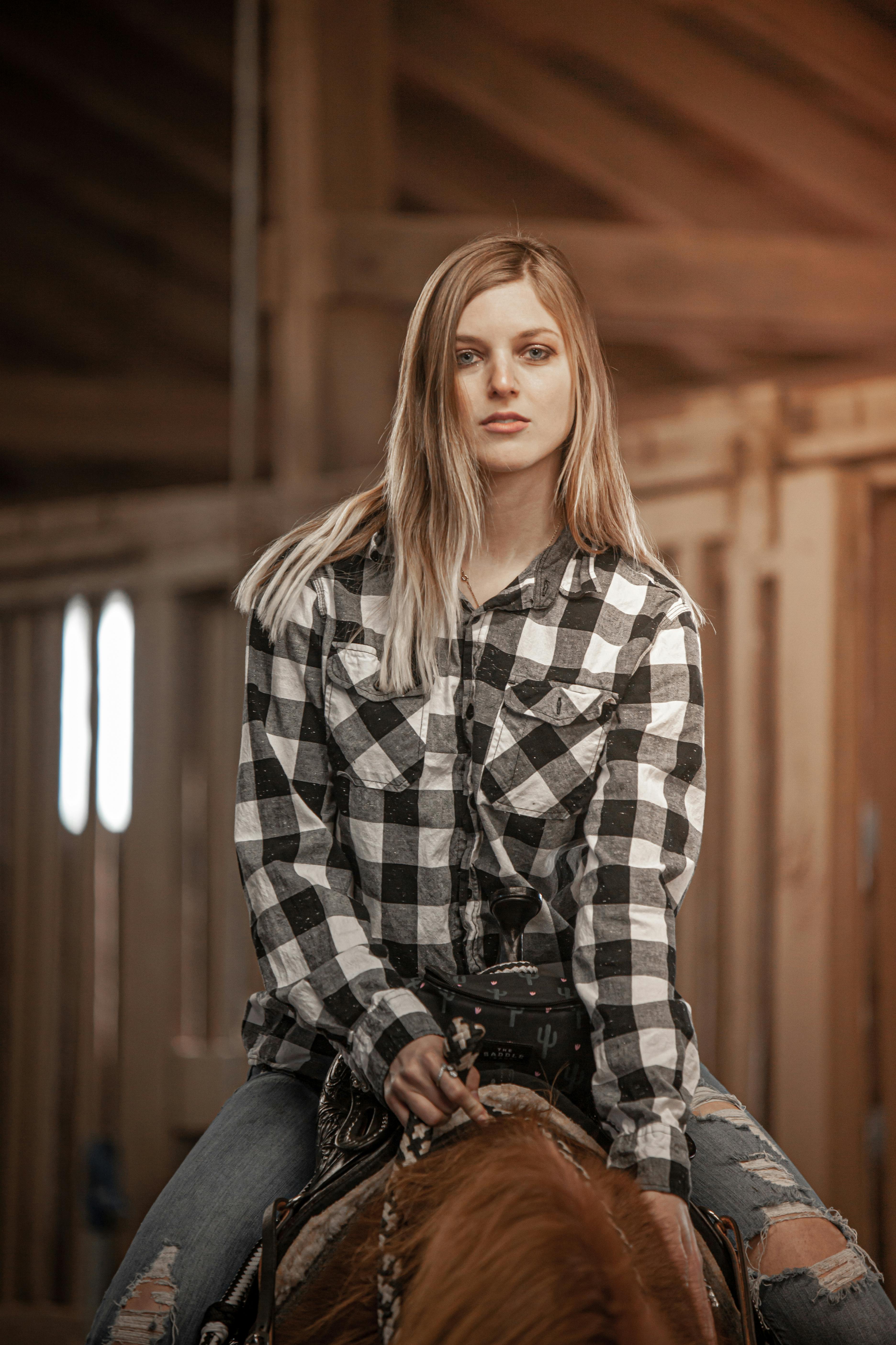 A Beautiful Woman Riding a Horse in a Stable · Free Stock Photo
