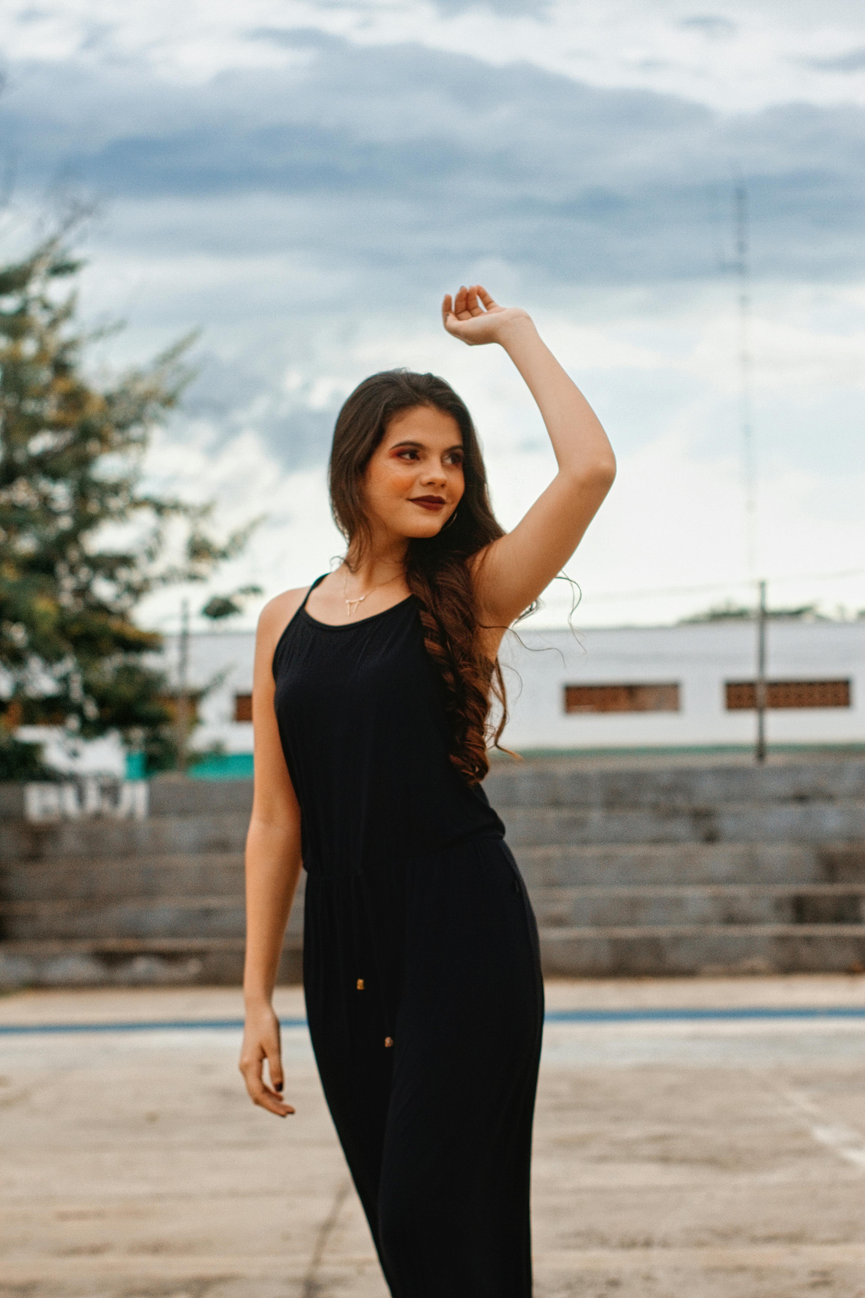 Woman in Black Waving Her Hand and Looking Over Shoulder · Free Stock Photo