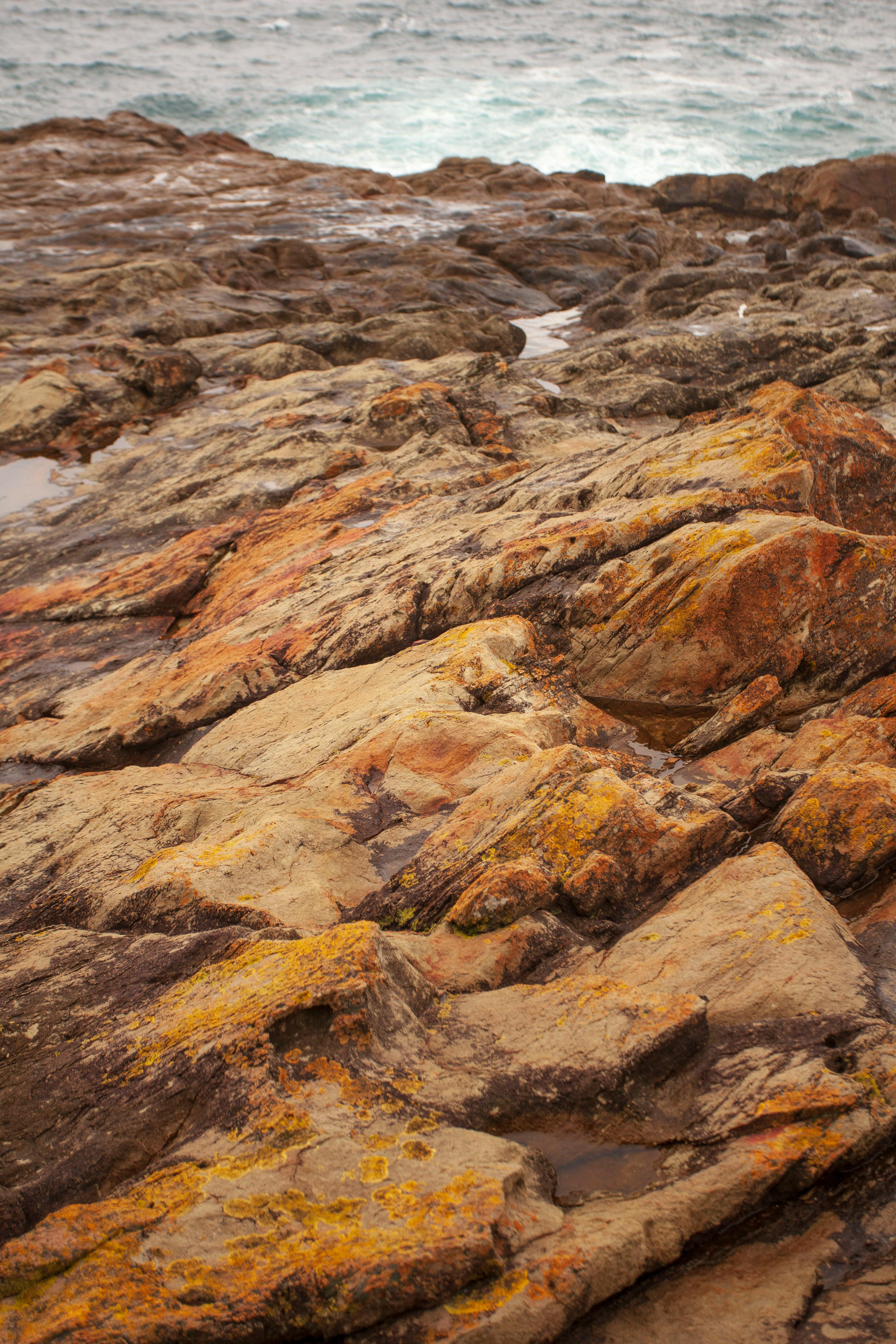 Brown Rock Formation Near Body of Water · Free Stock Photo