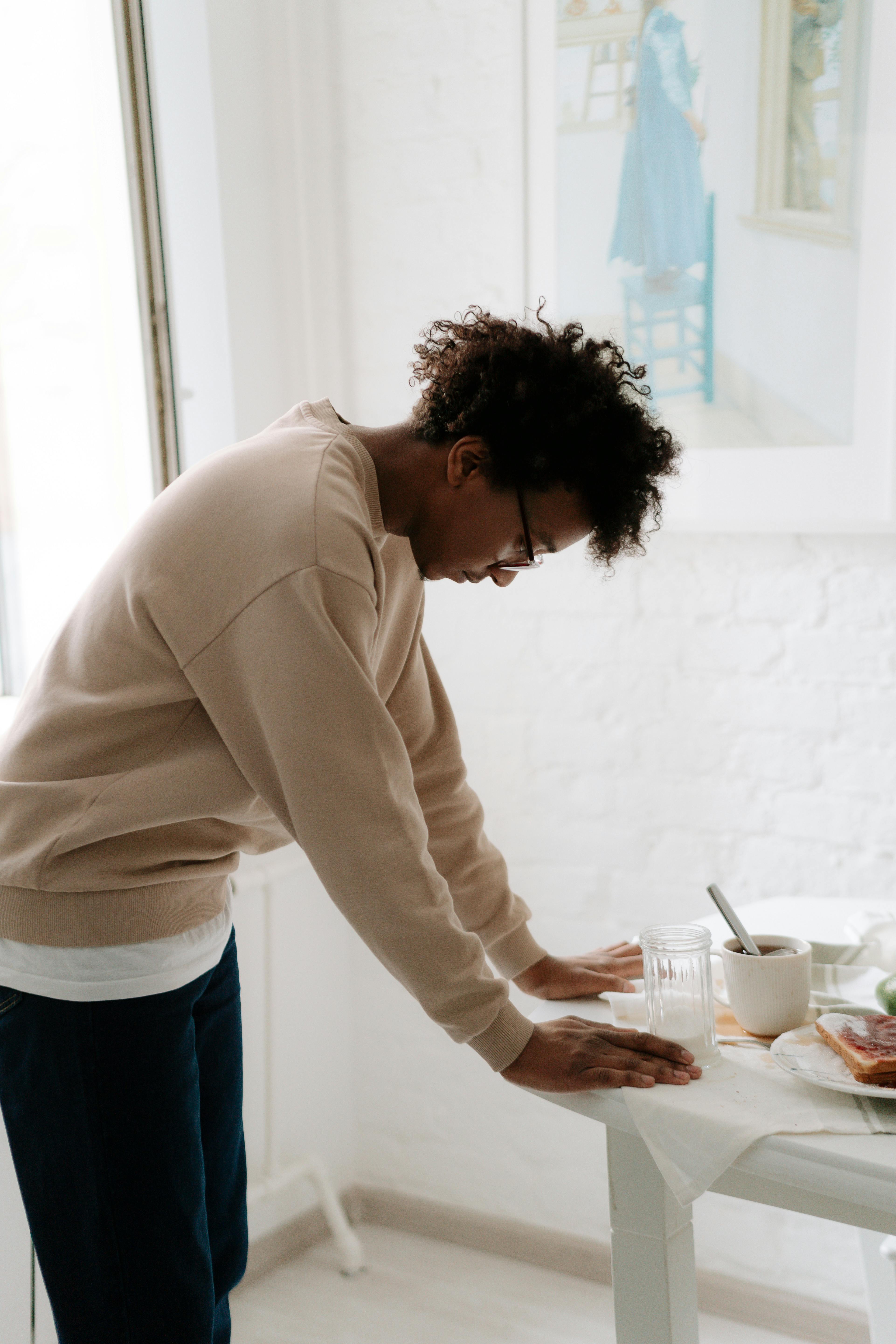 Person Looking Down at Hands on Table · Free Stock Photo