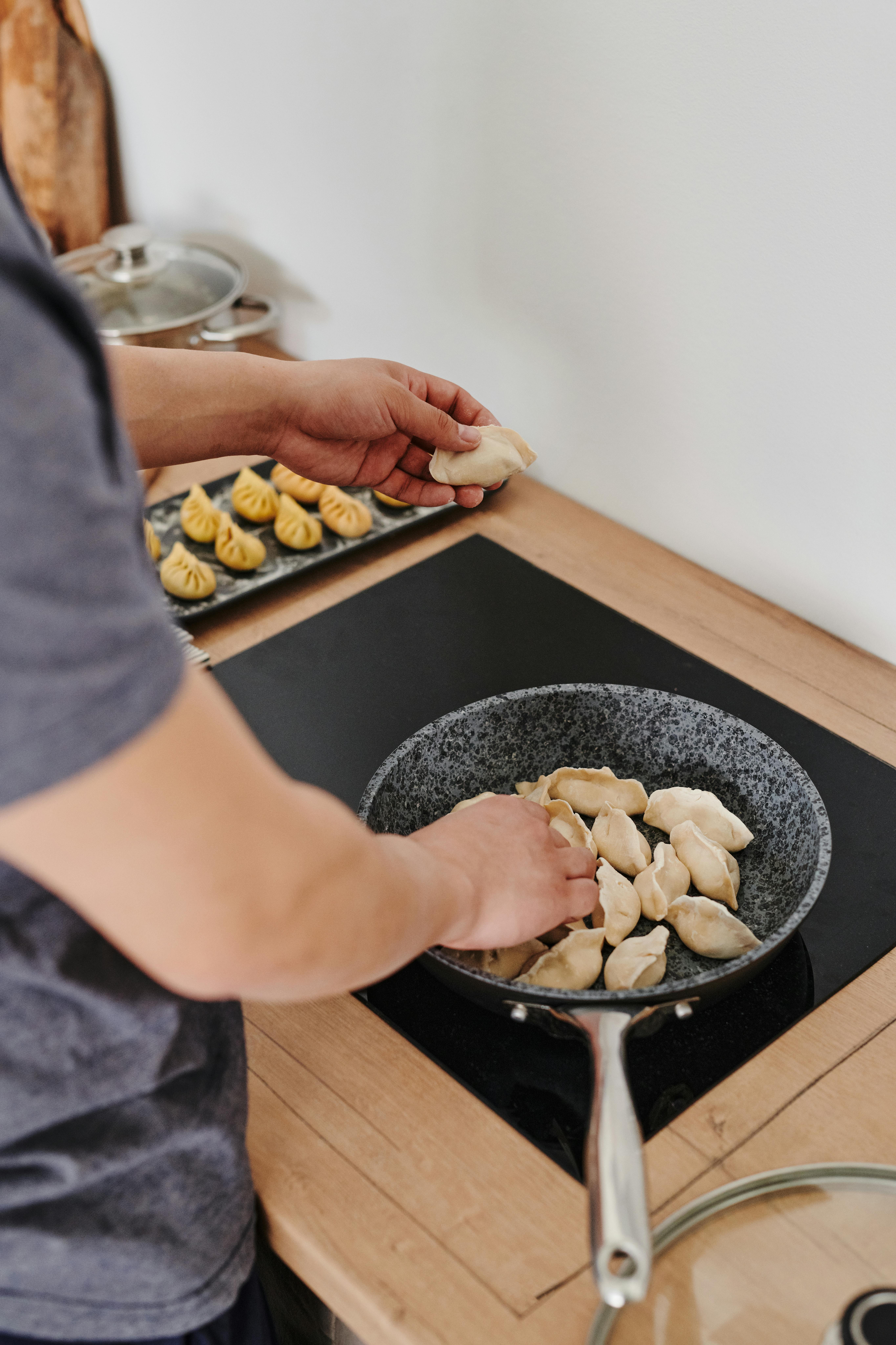 Close-Up Shot of a Person Cooking Dumplings · Free Stock Photo