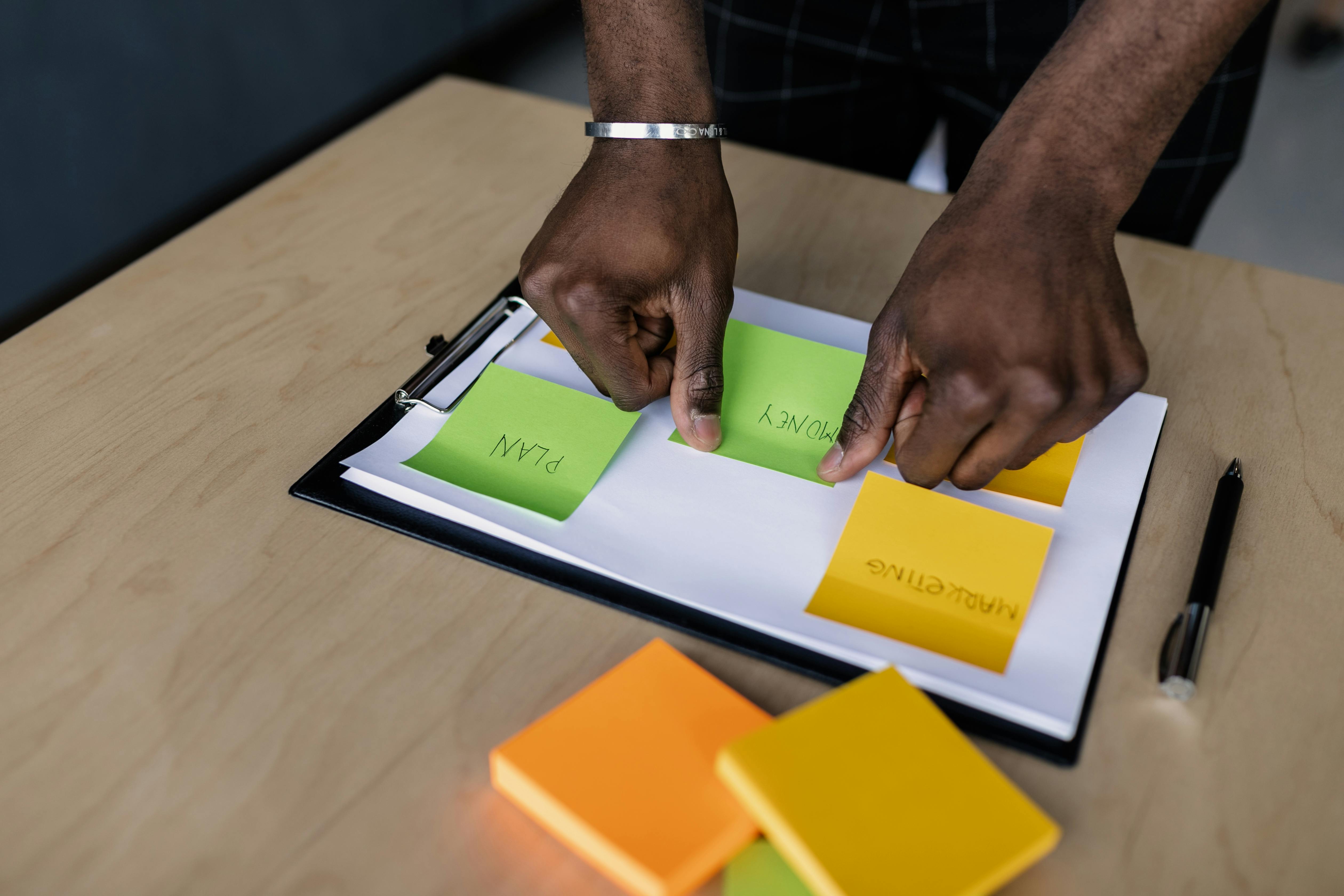 A Person Sticking Sticky Notes on a Paper · Free Stock Photo