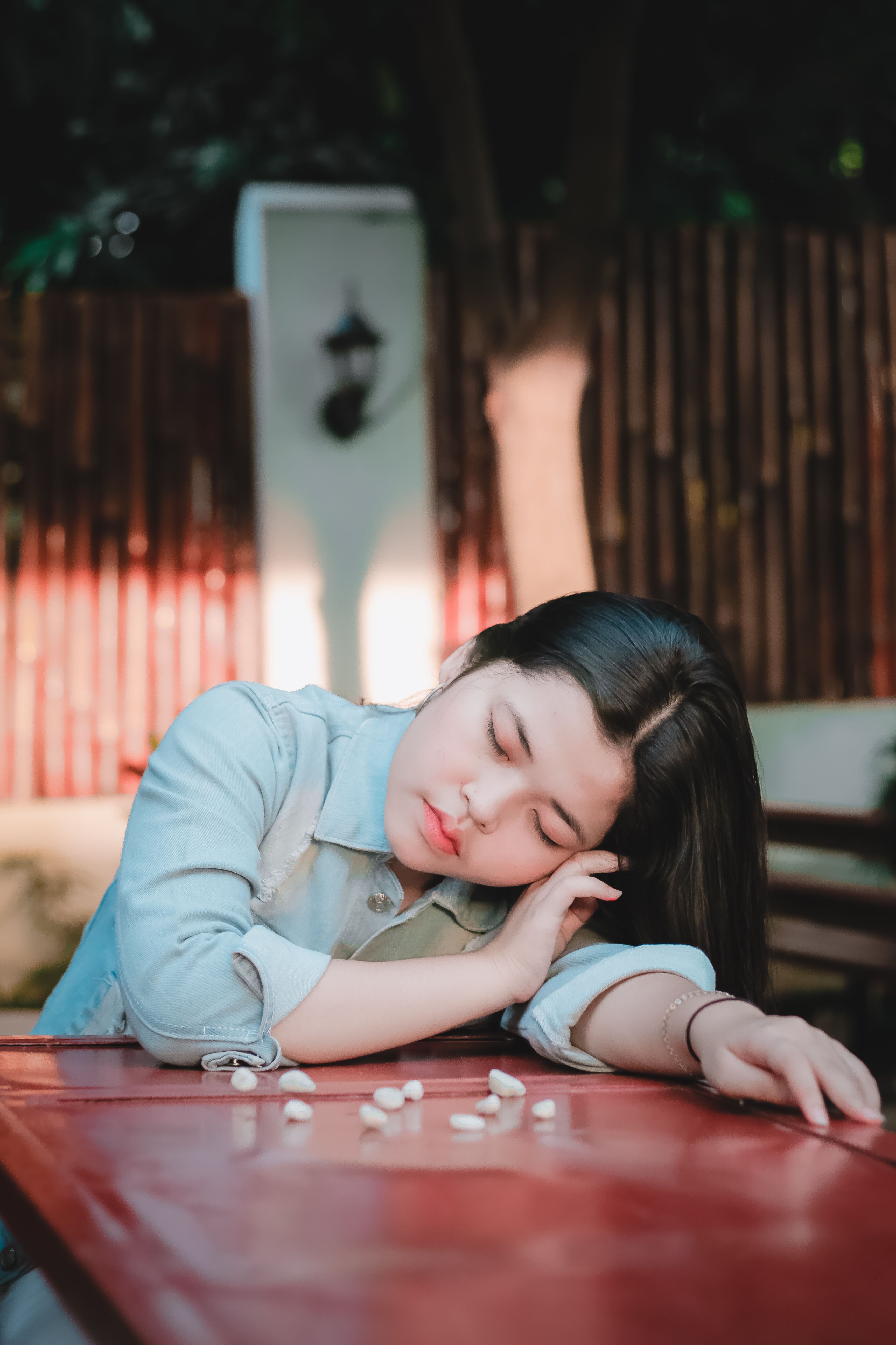 Woman Resting Head on Hands Lying on Table · Free Stock Photo