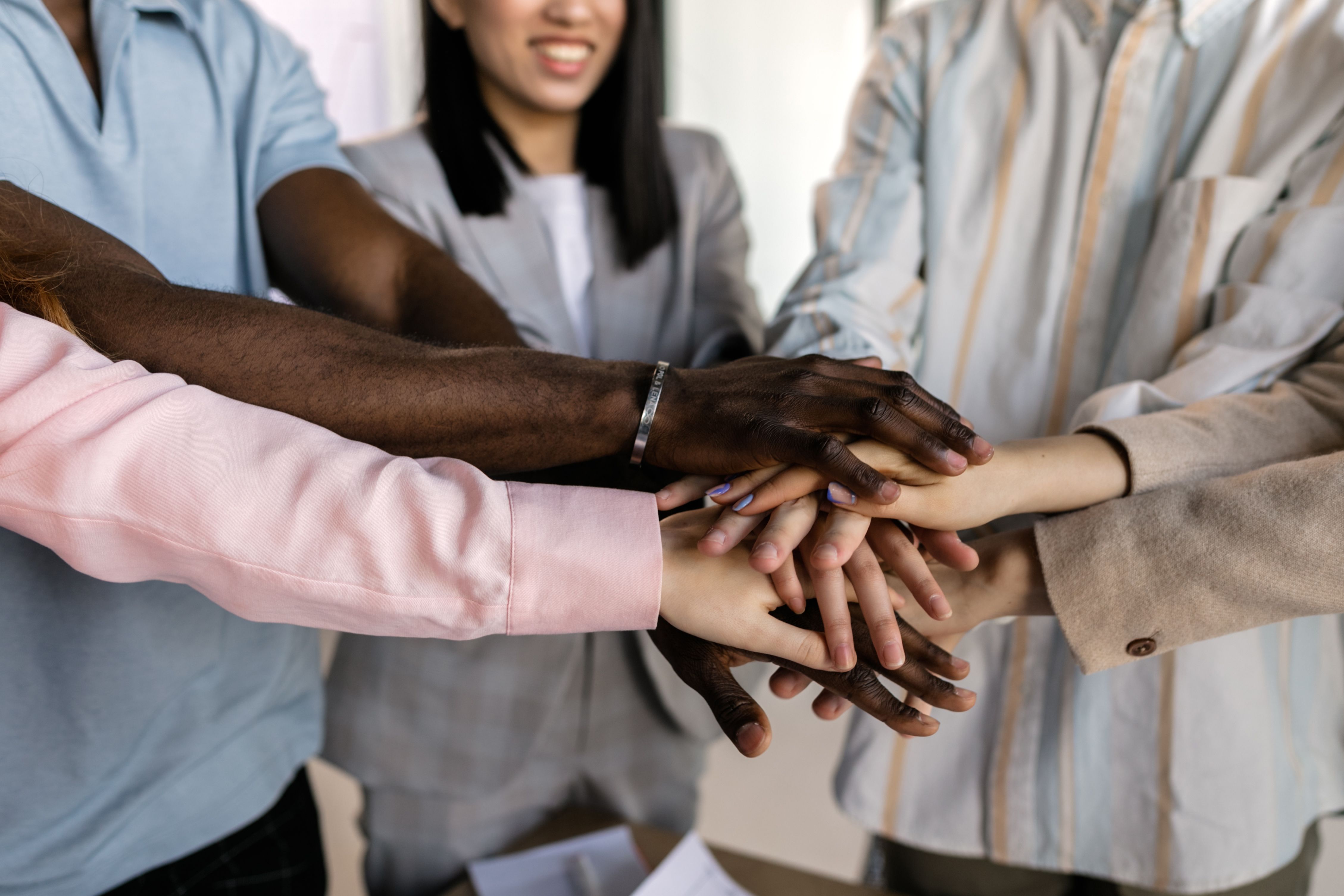 A Group of People Piling Hands on Top of Each Other · Free Stock Photo