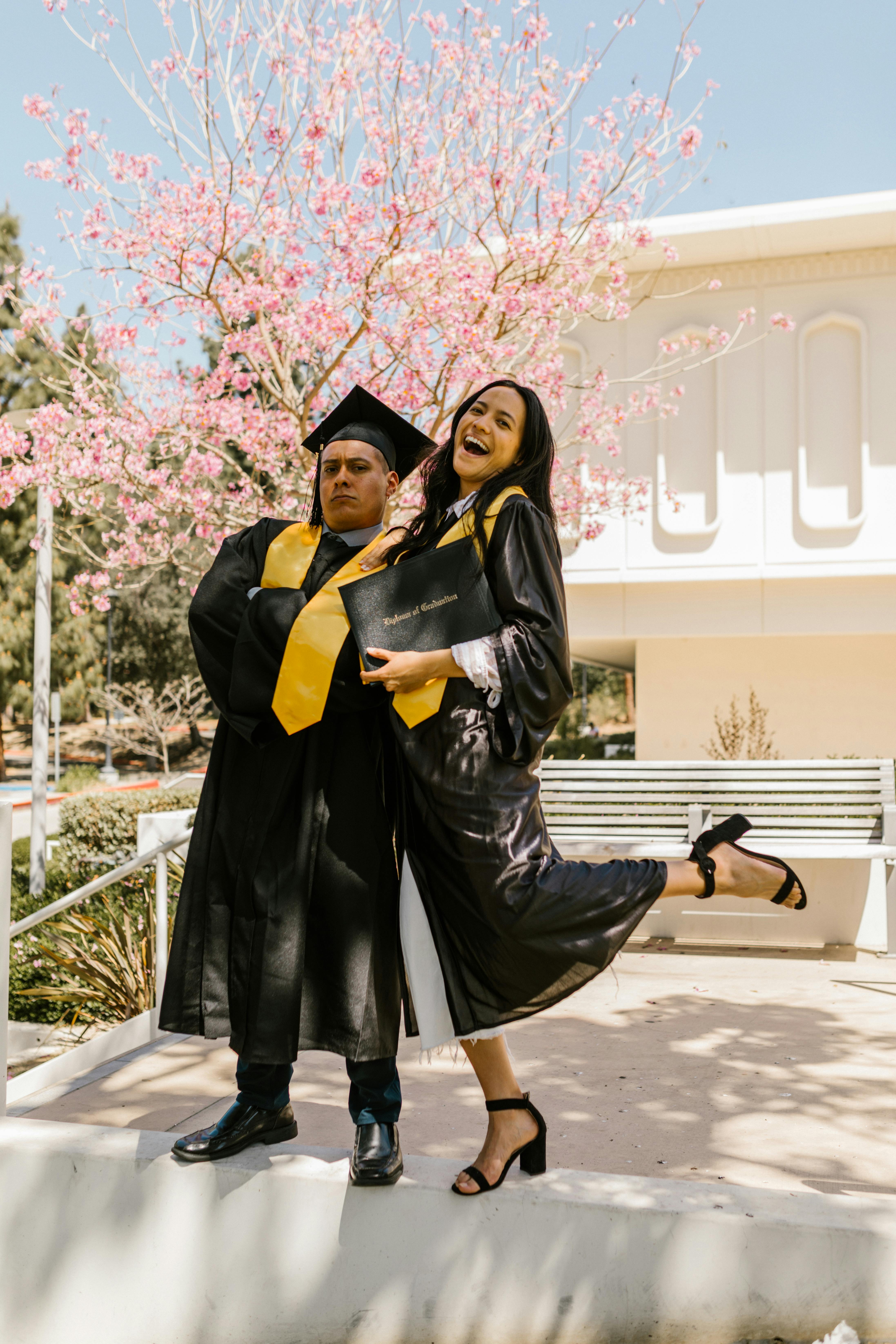 Two Graduates Standing and Smiling · Free Stock Photo