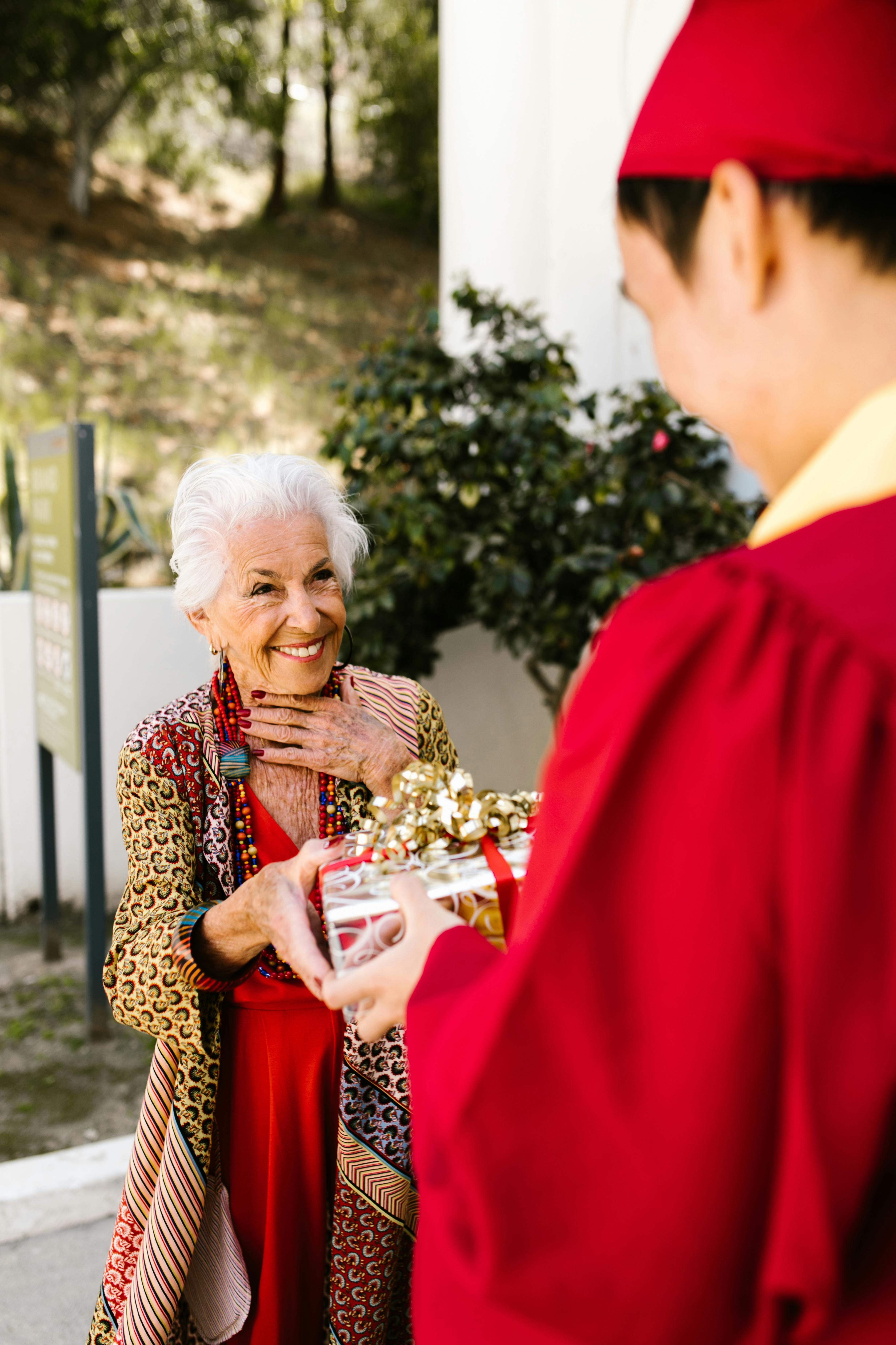 Woman Giving Gift to Graduate · Free Stock Photo