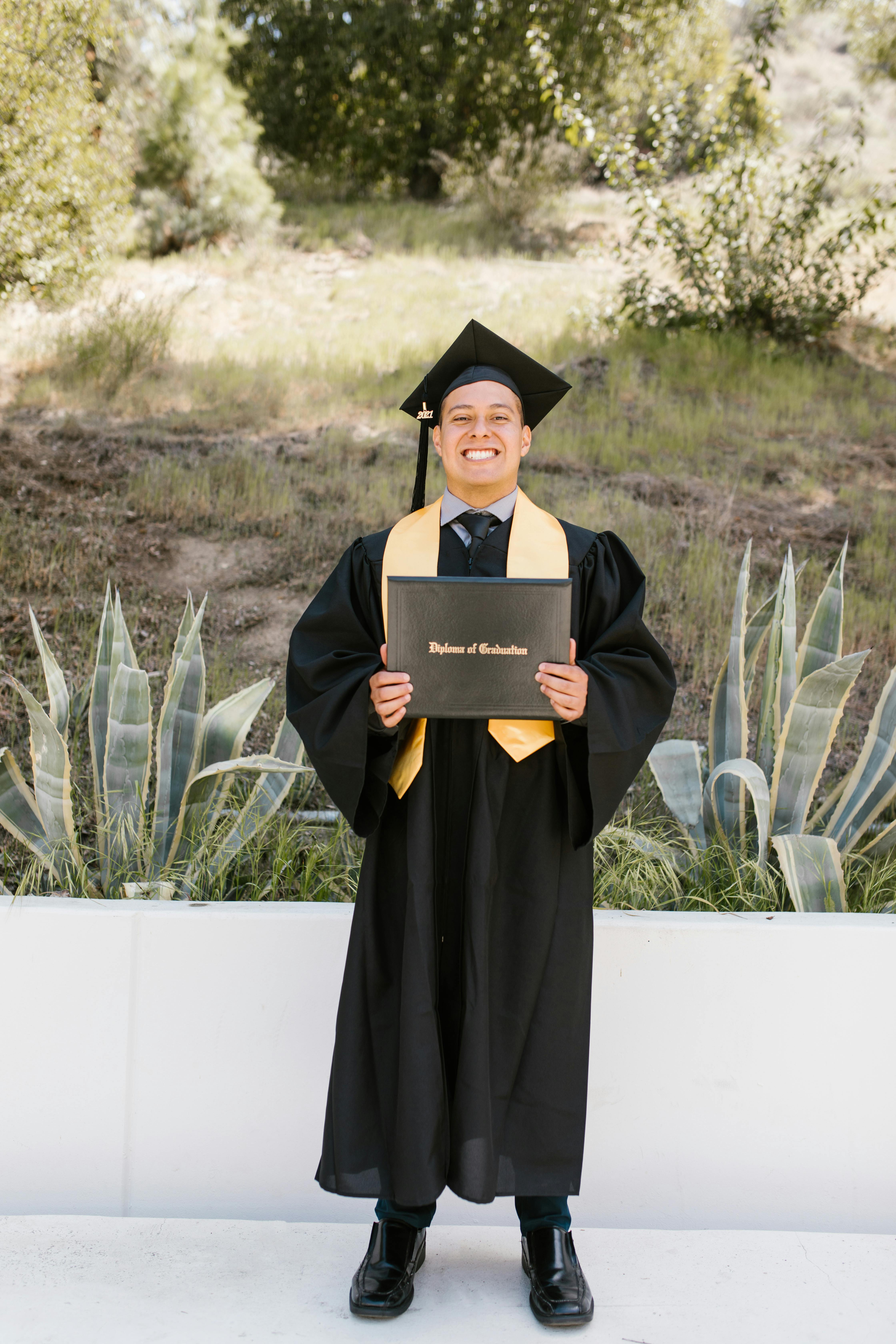 Newly Graduate Students Posing with Their Hands Raised · Free Stock Photo