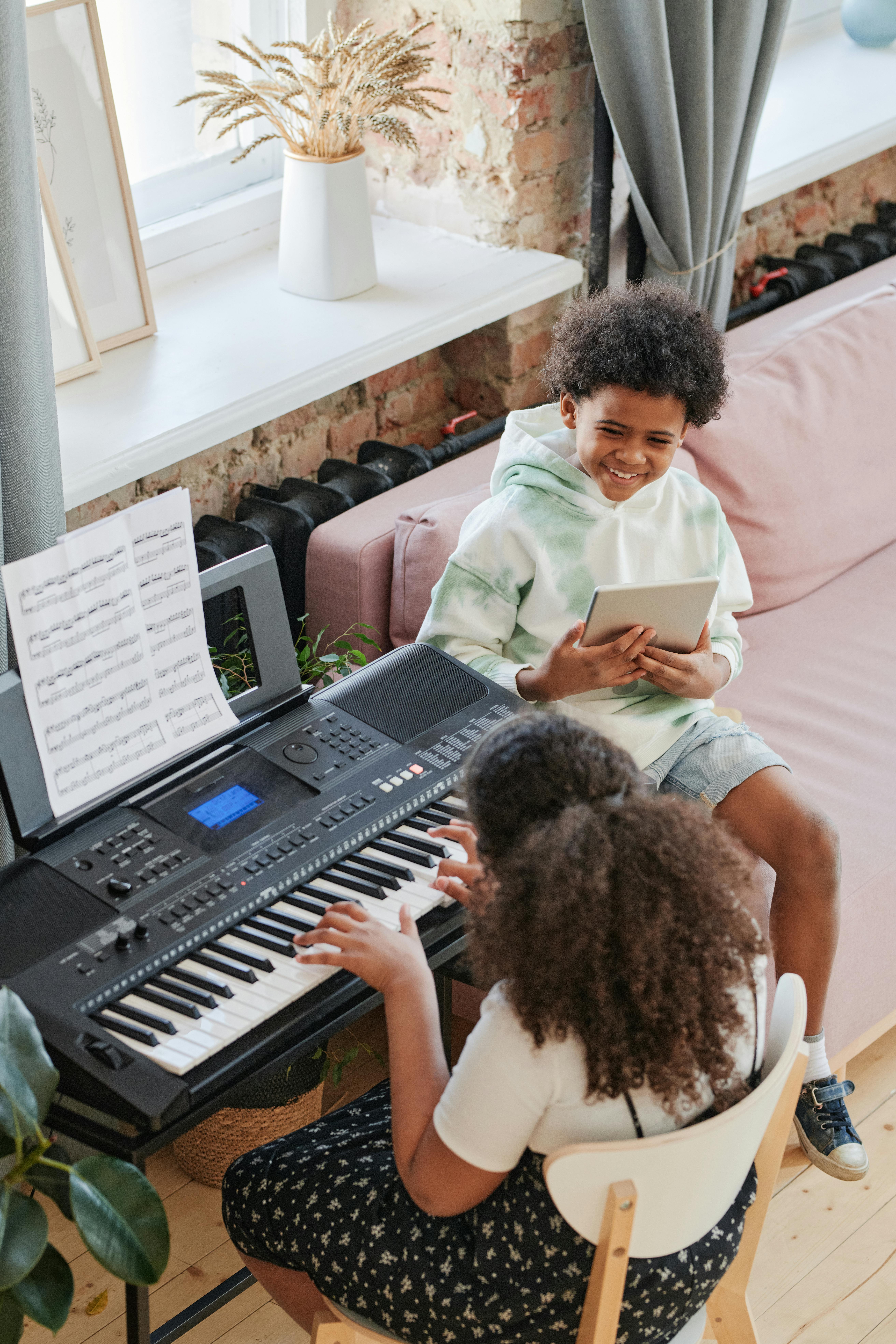 A Boy Sitting Beside a Girl Playing the Synthesizer · Free Stock Photo