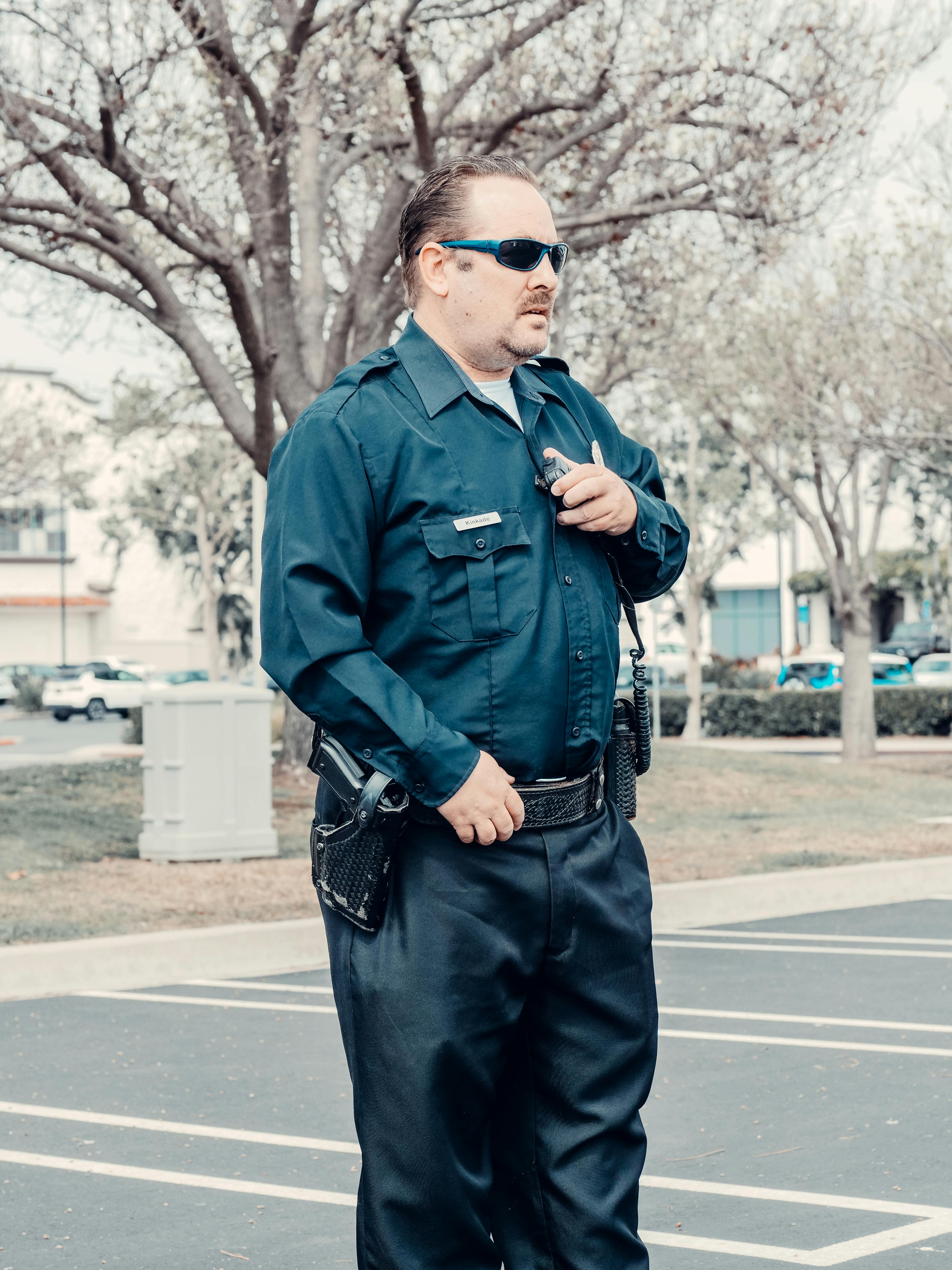Man in Blue Police Uniform Standing on Road · Free Stock Photo