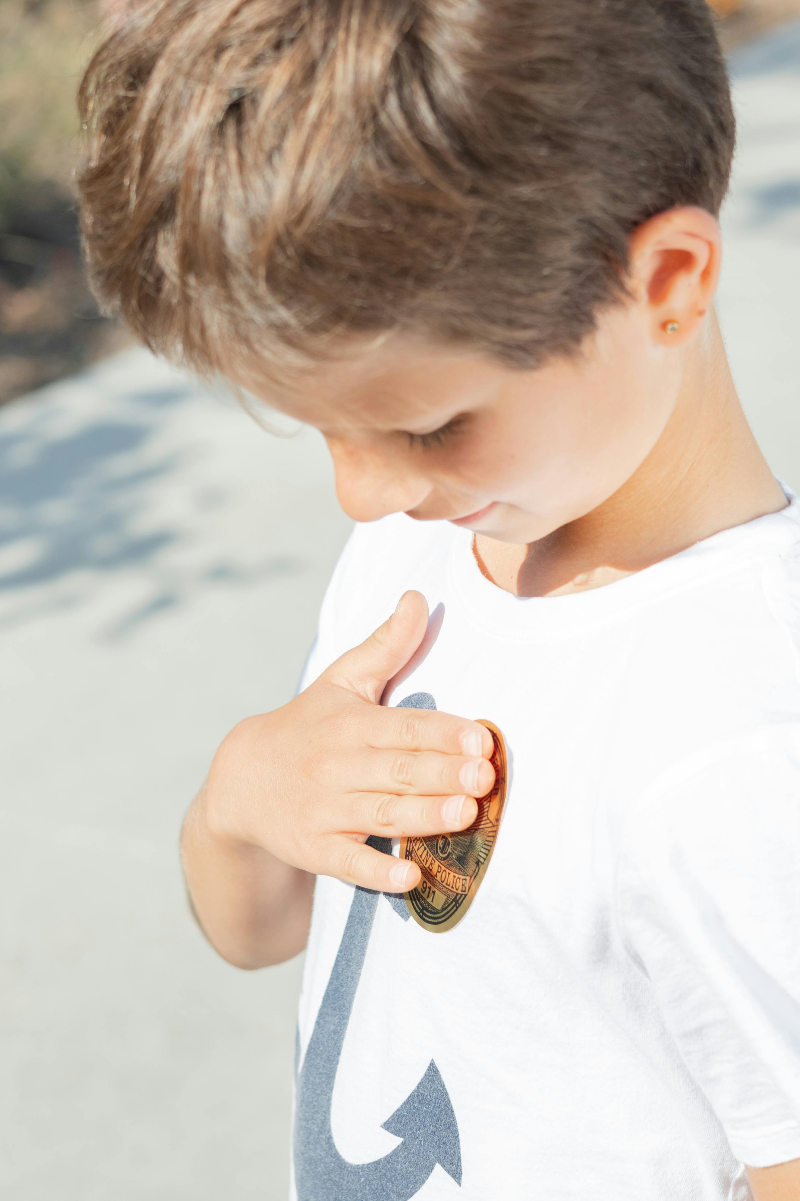 A Boy Putting a Sticker on His Shirt · Free Stock Photo