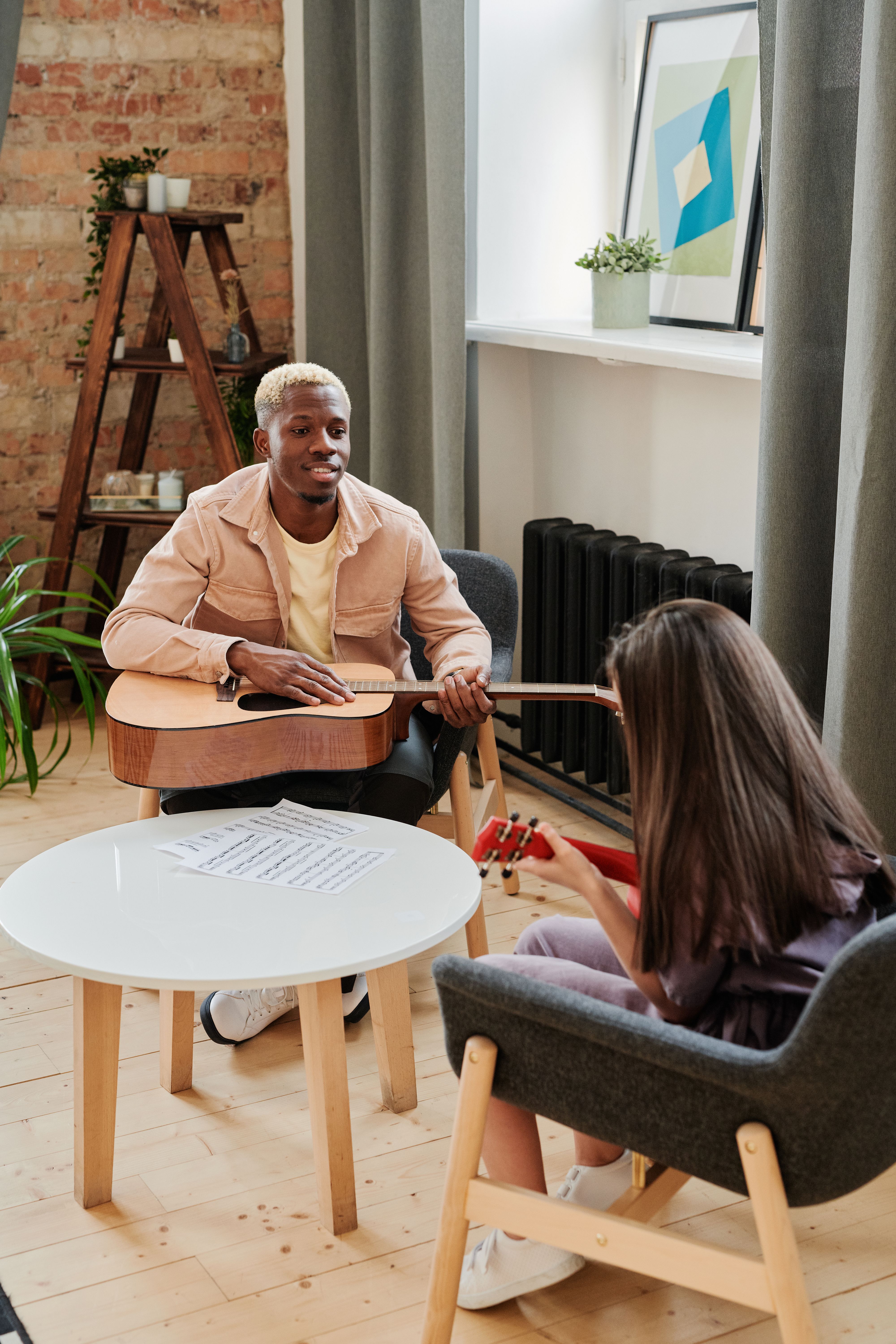 A Man and a Girl Putting on Strings on a Guitar · Free Stock Photo