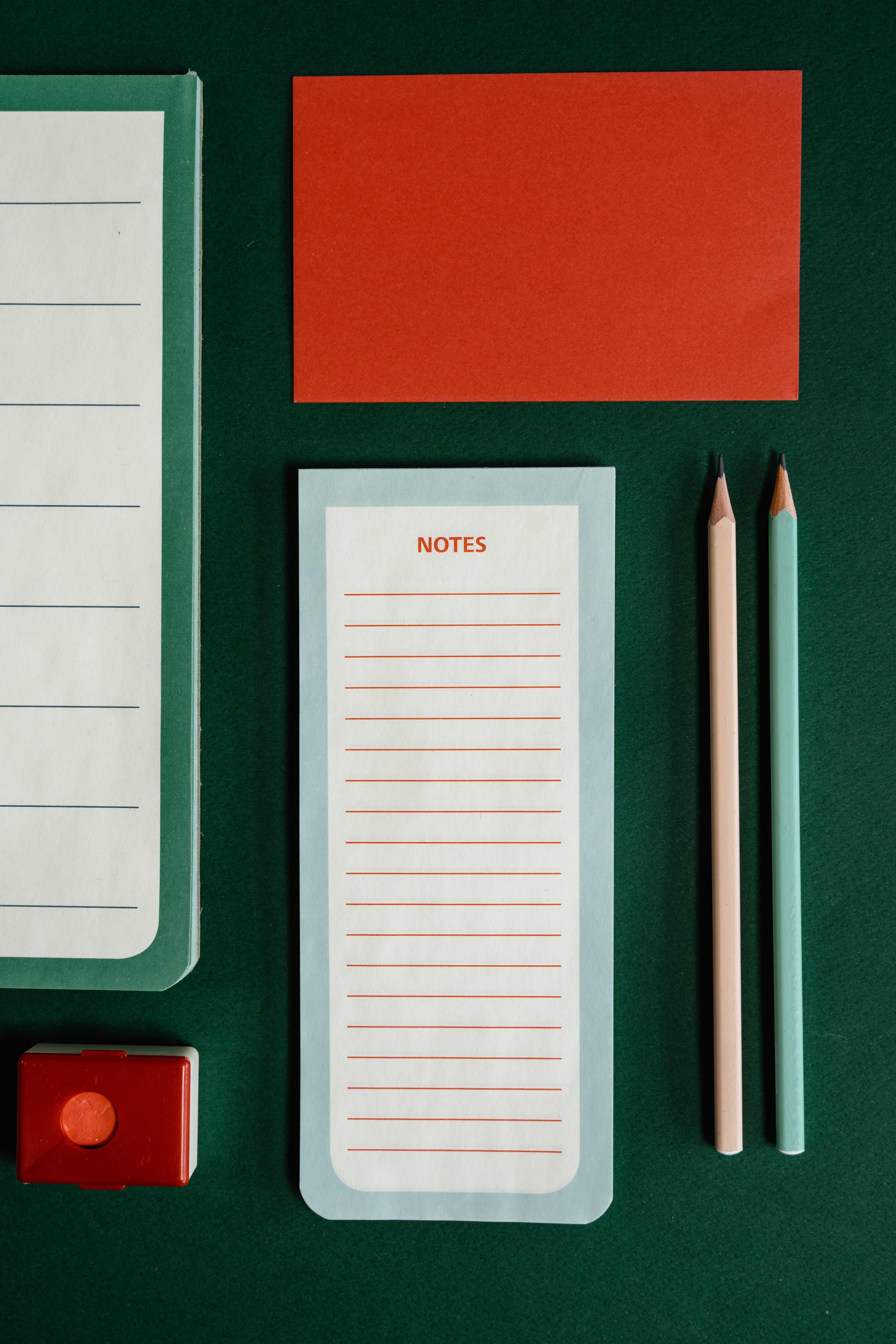 A Colorful Papers and Pencils on Green Surface · Free Stock Photo
