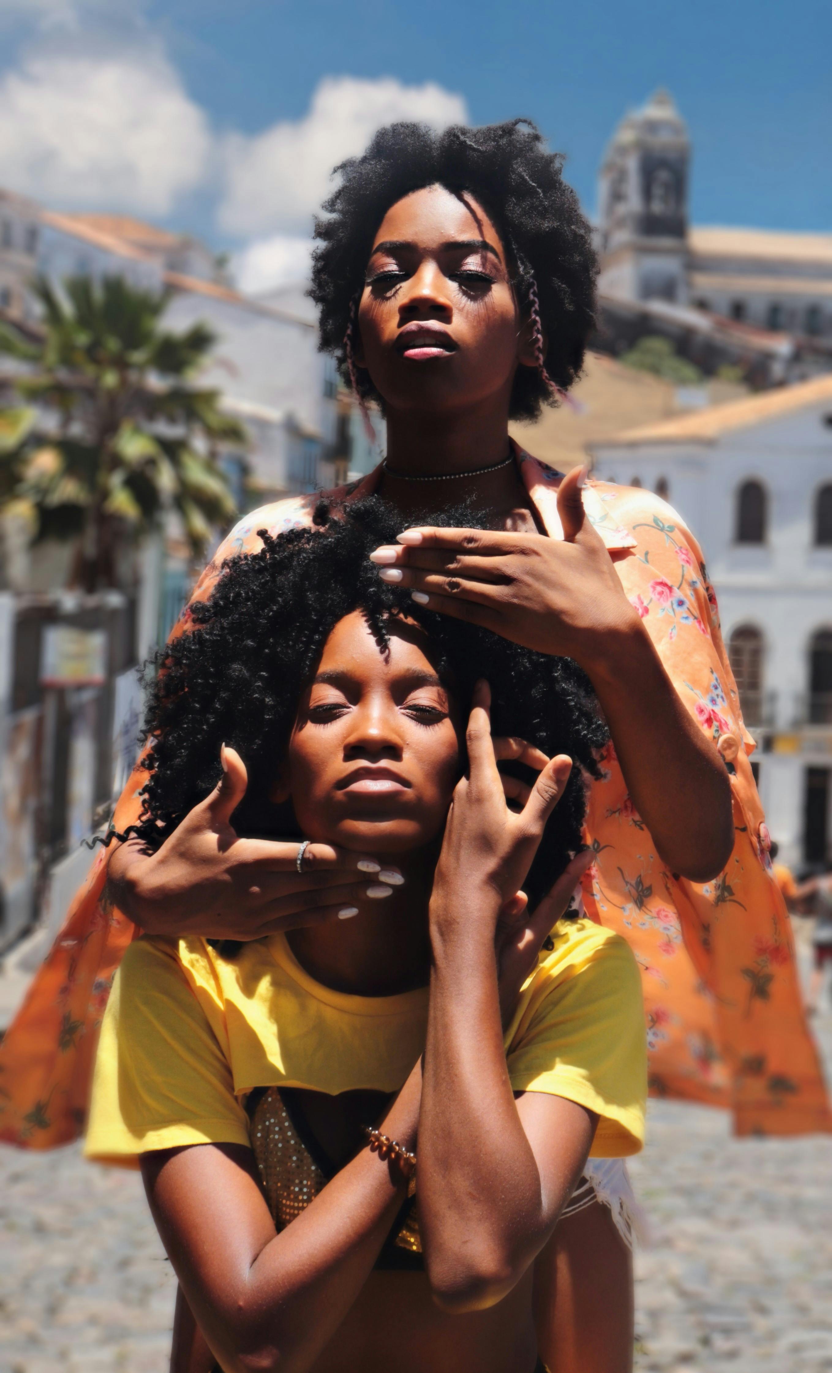 Women Crossing Arms Across Shoulders · Free Stock Photo