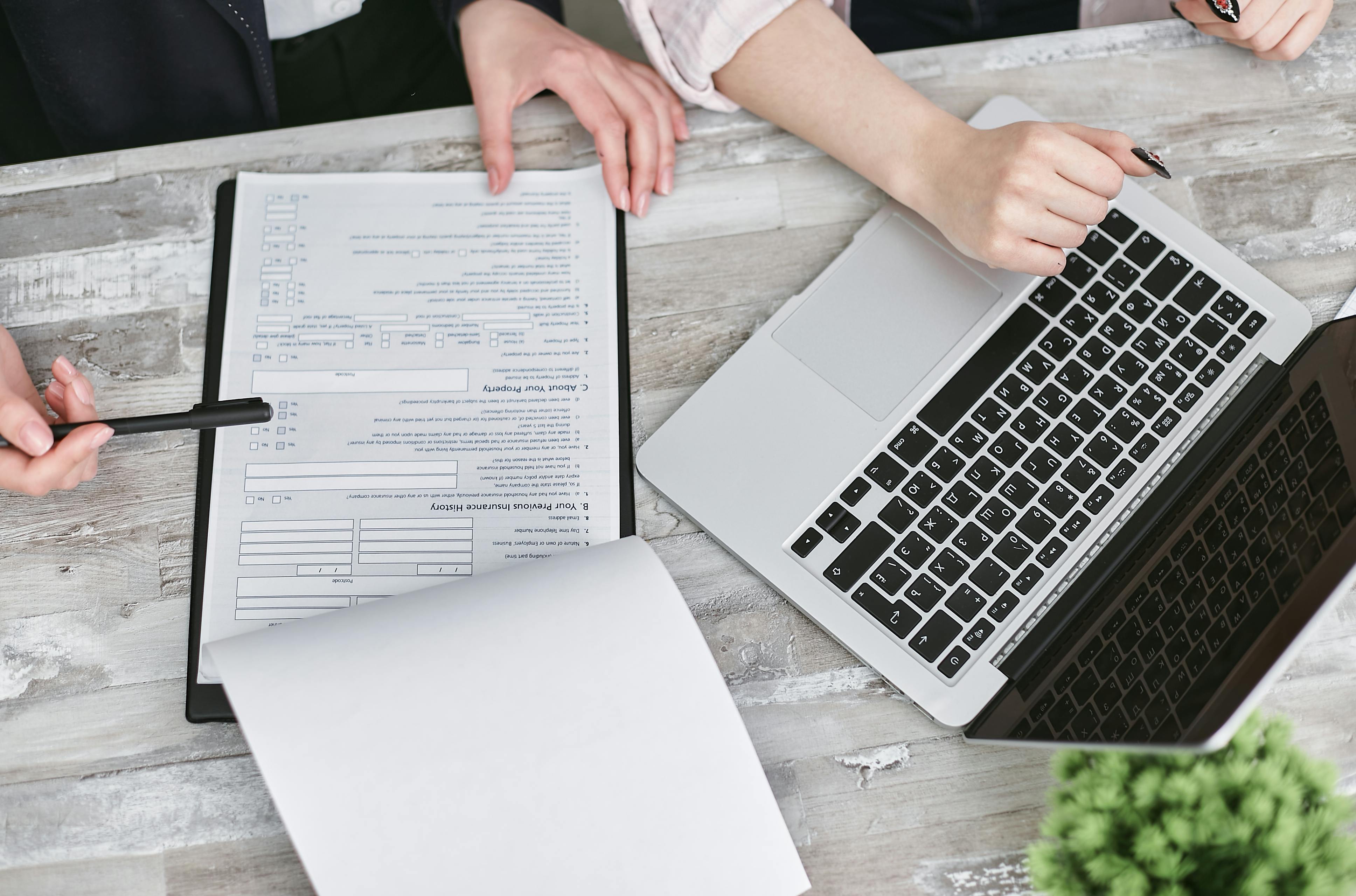 Documents and a Laptop on a Table · Free Stock Photo