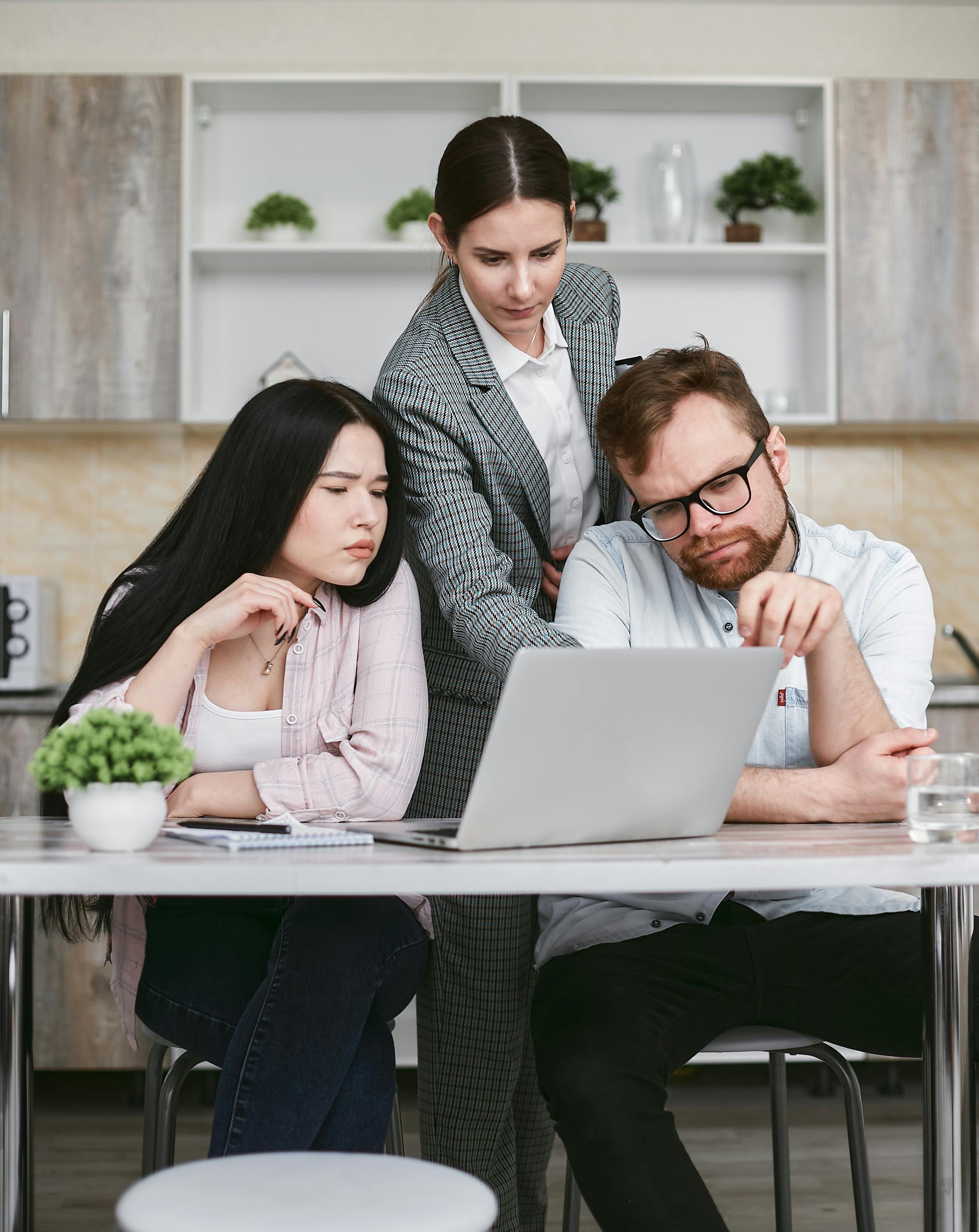 Employees Looking at the Screen of a Laptop while Having a Conversation ...