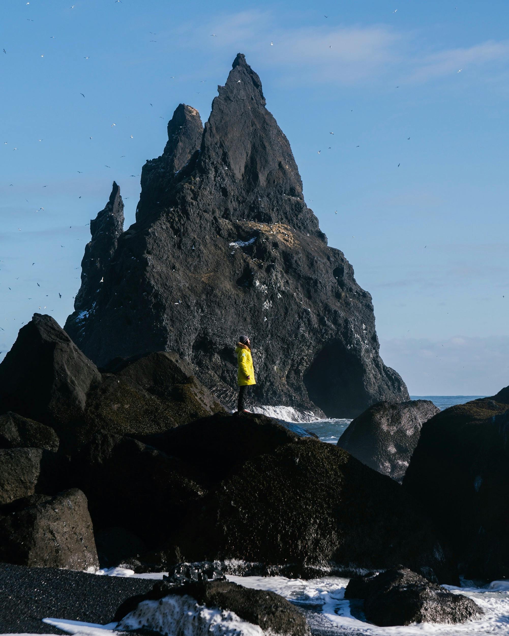 Woman in Yellow Jacket and Yellow Hat Standing on Black Sand · Free ...