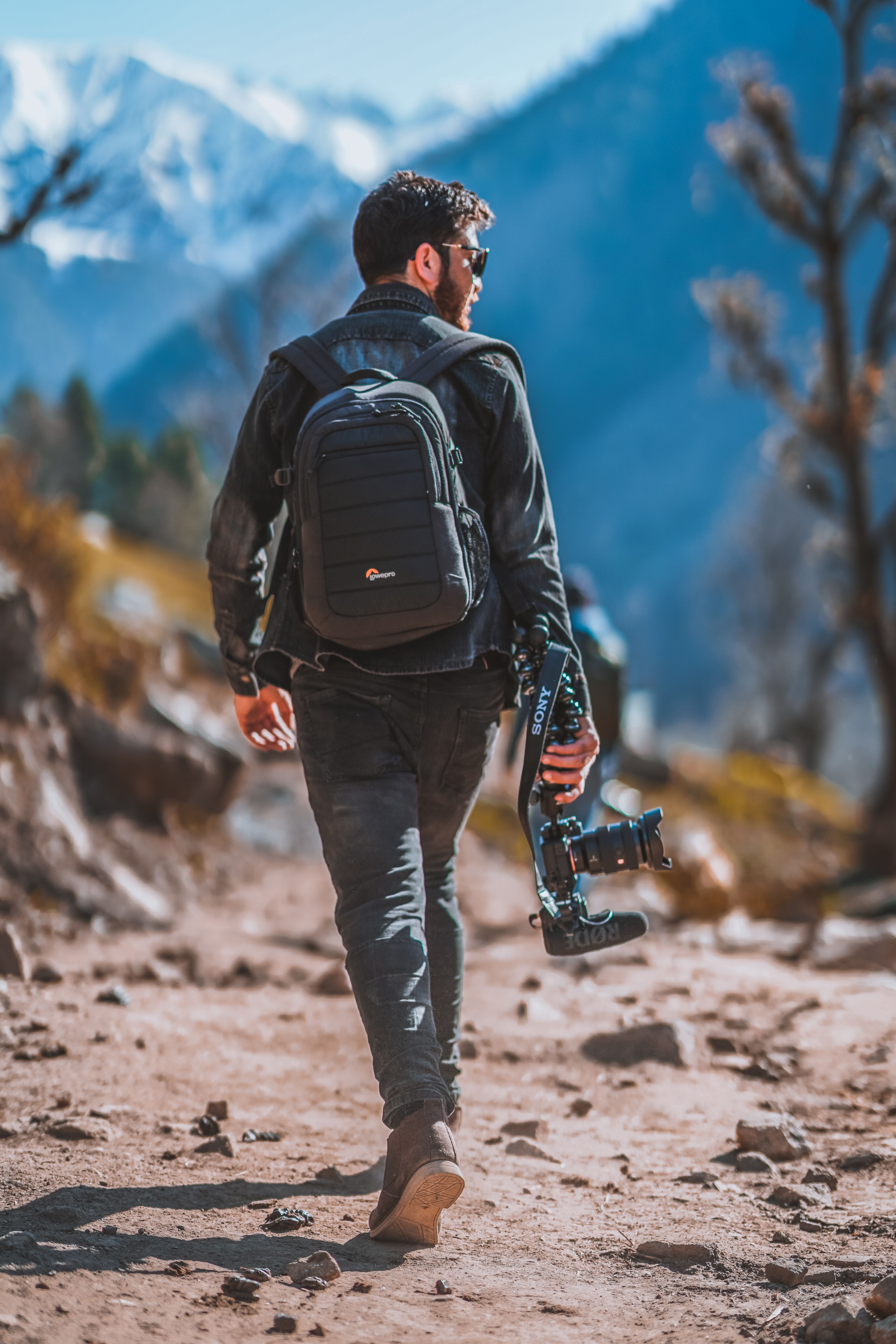 Survivalist with a Bow and a Backpack Standing in a Mountain Pasture ...