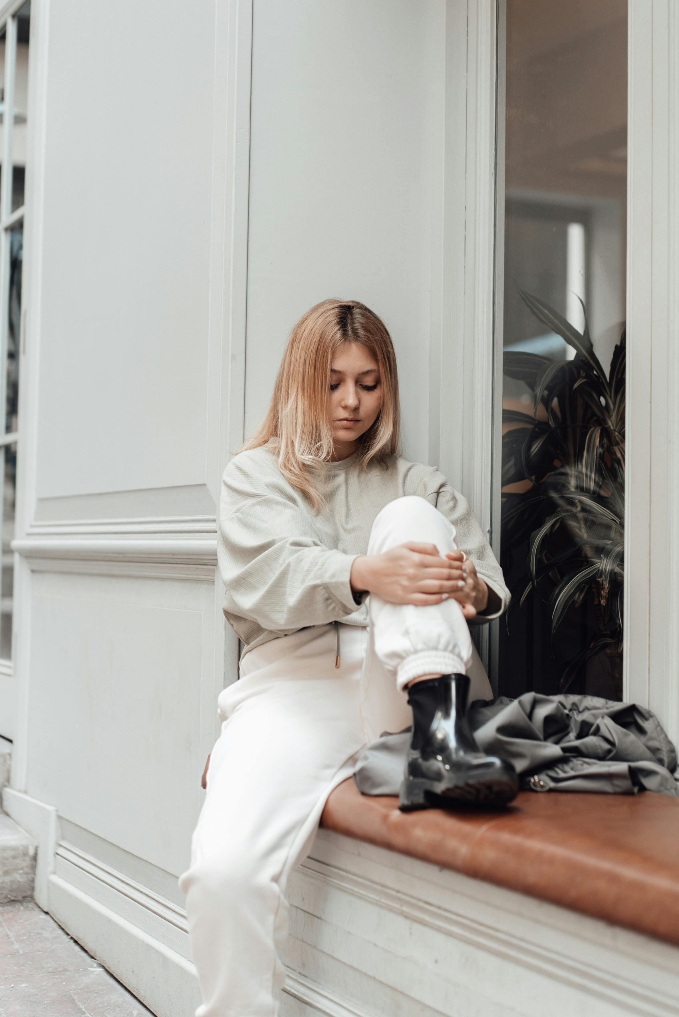A Woman in a Stylish Outfit Sitting on a Bench Seat · Free Stock Photo