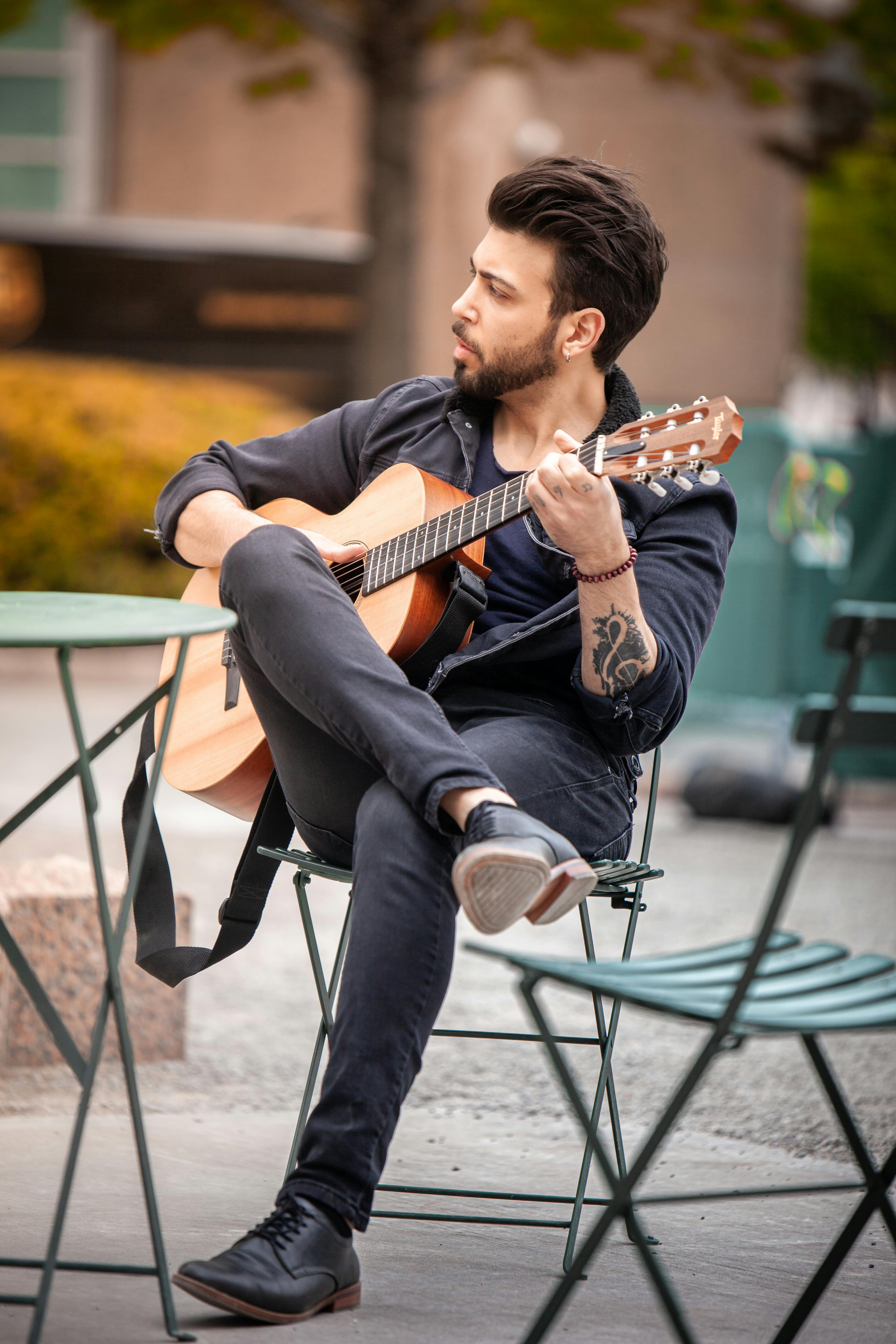 Man Sitting and Playing Guitar · Free Stock Photo