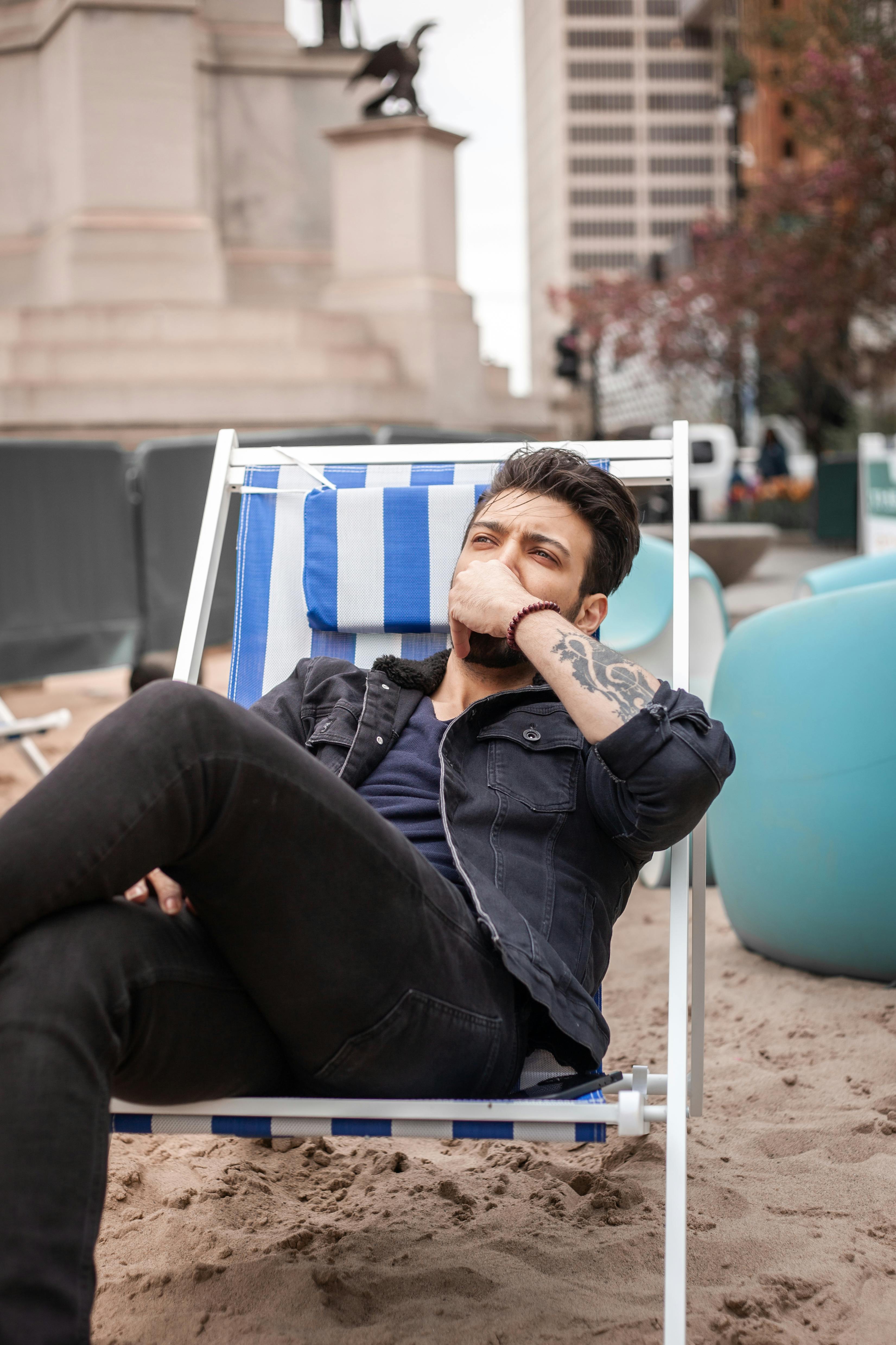 Man Sitting on a Chair on a Beach · Free Stock Photo