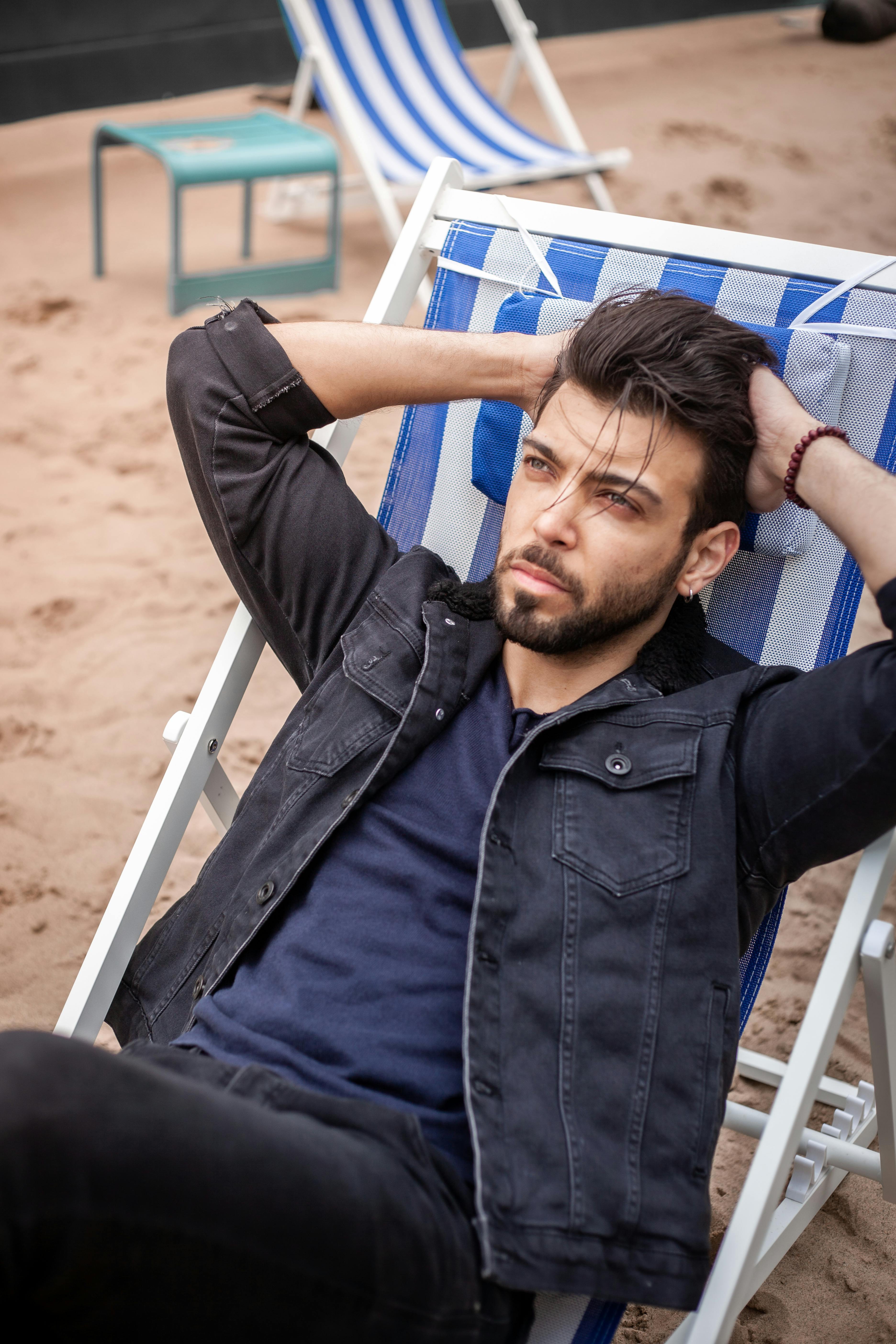 Man Sitting on a Chair on a Beach · Free Stock Photo