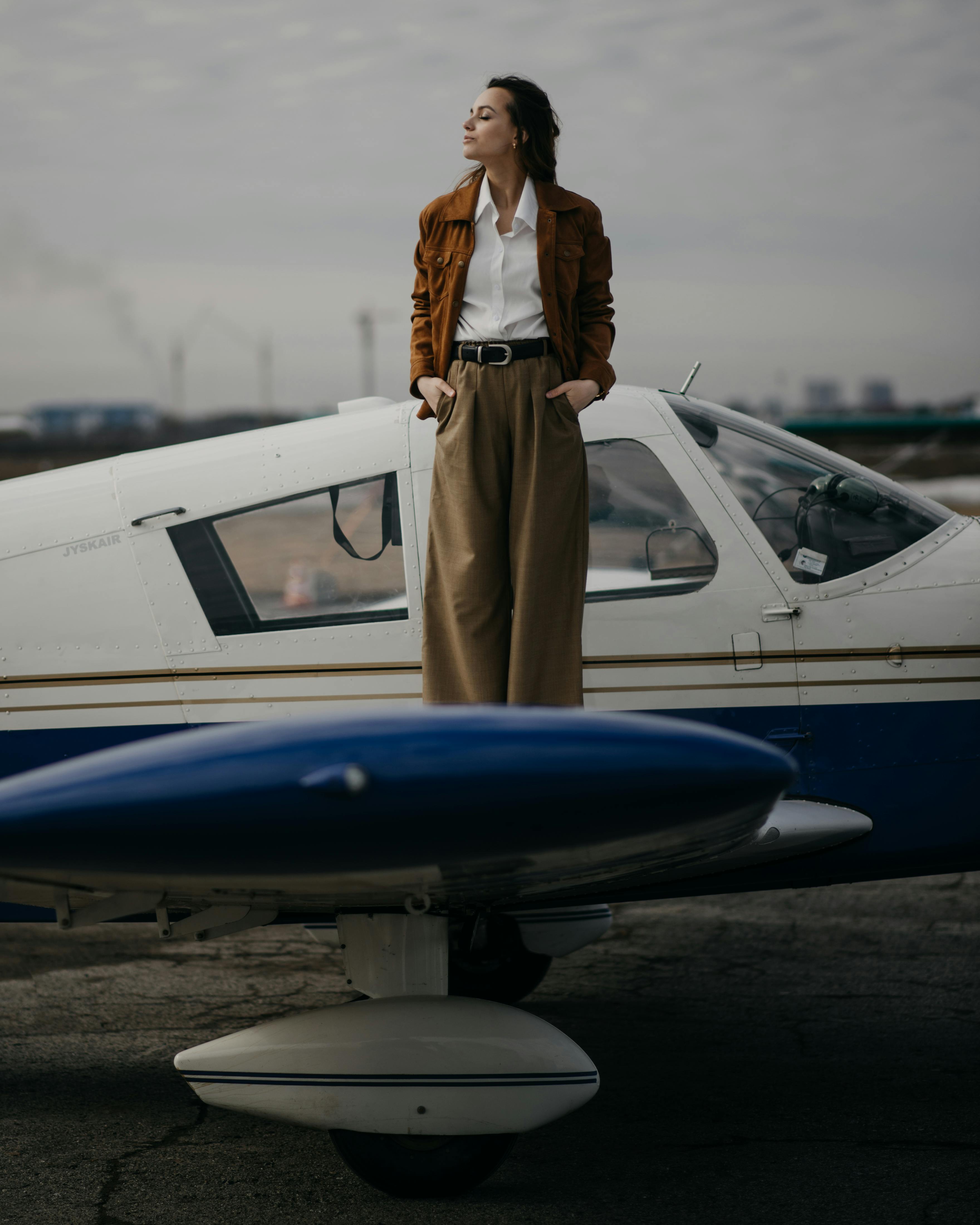 Elegant dwoman standing on wing of plane · Free Stock Photo