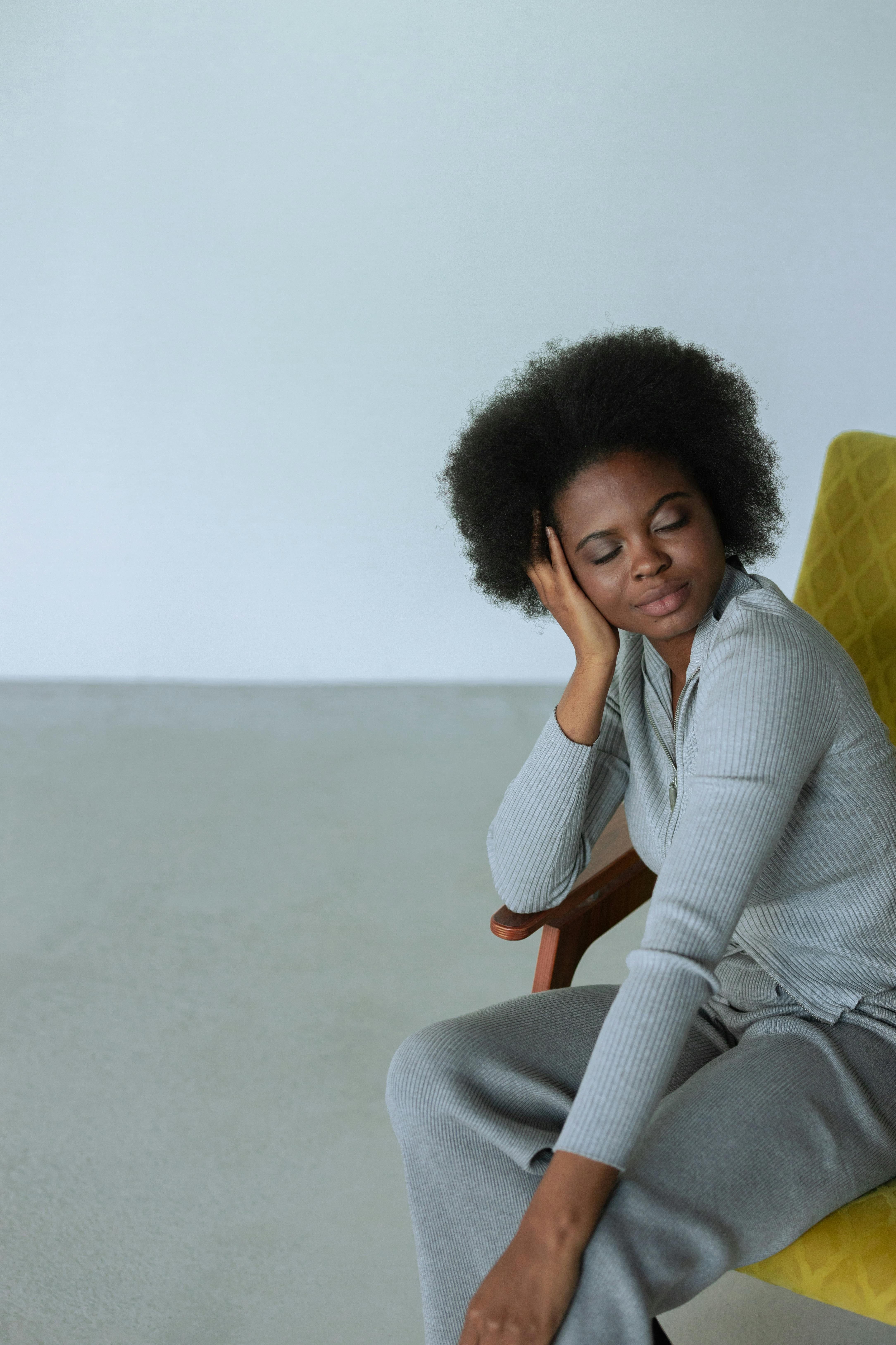 Woman Sitting on Chair Beside Green Plant · Free Stock Photo
