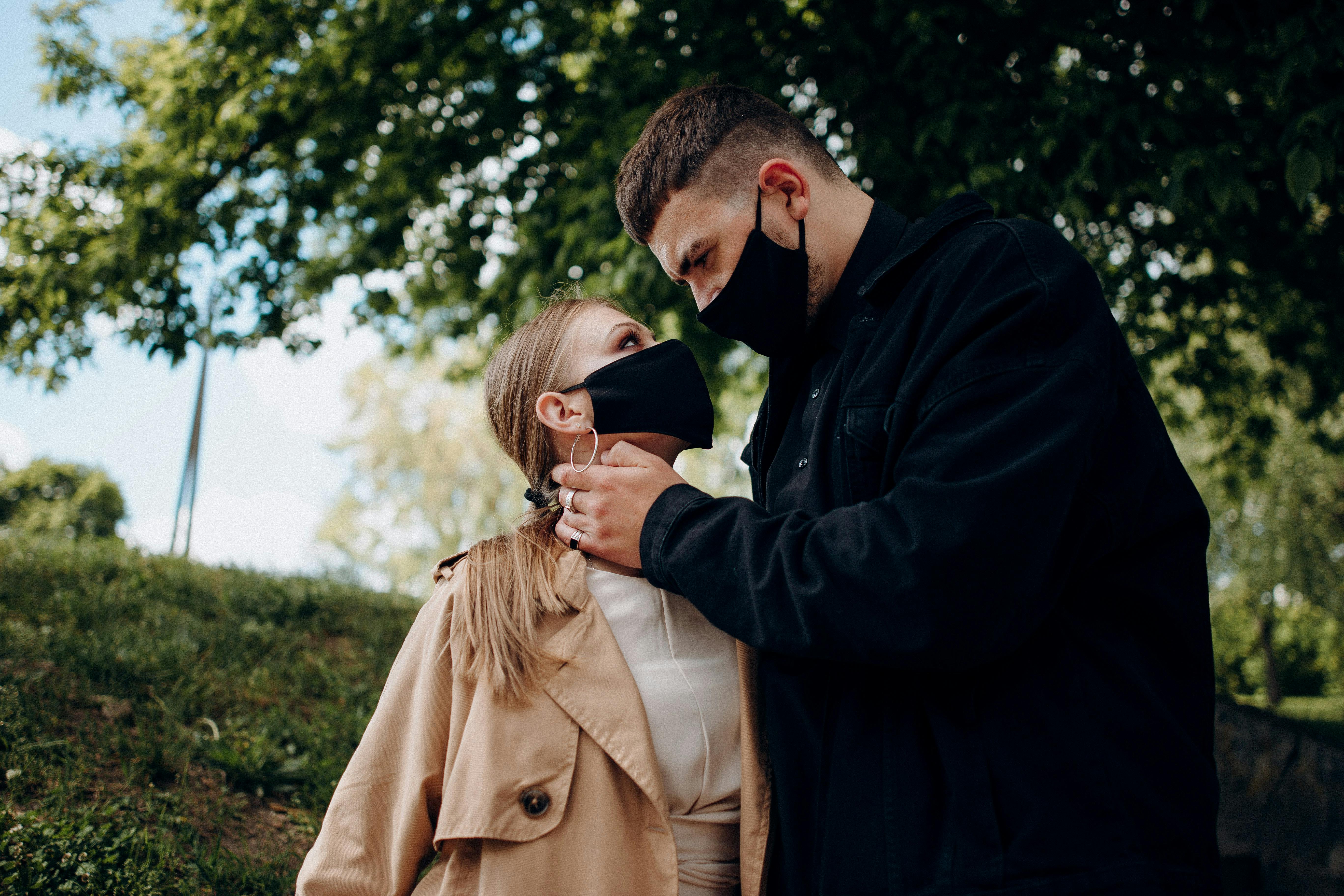 Couple in masks standing in park · Free Stock Photo