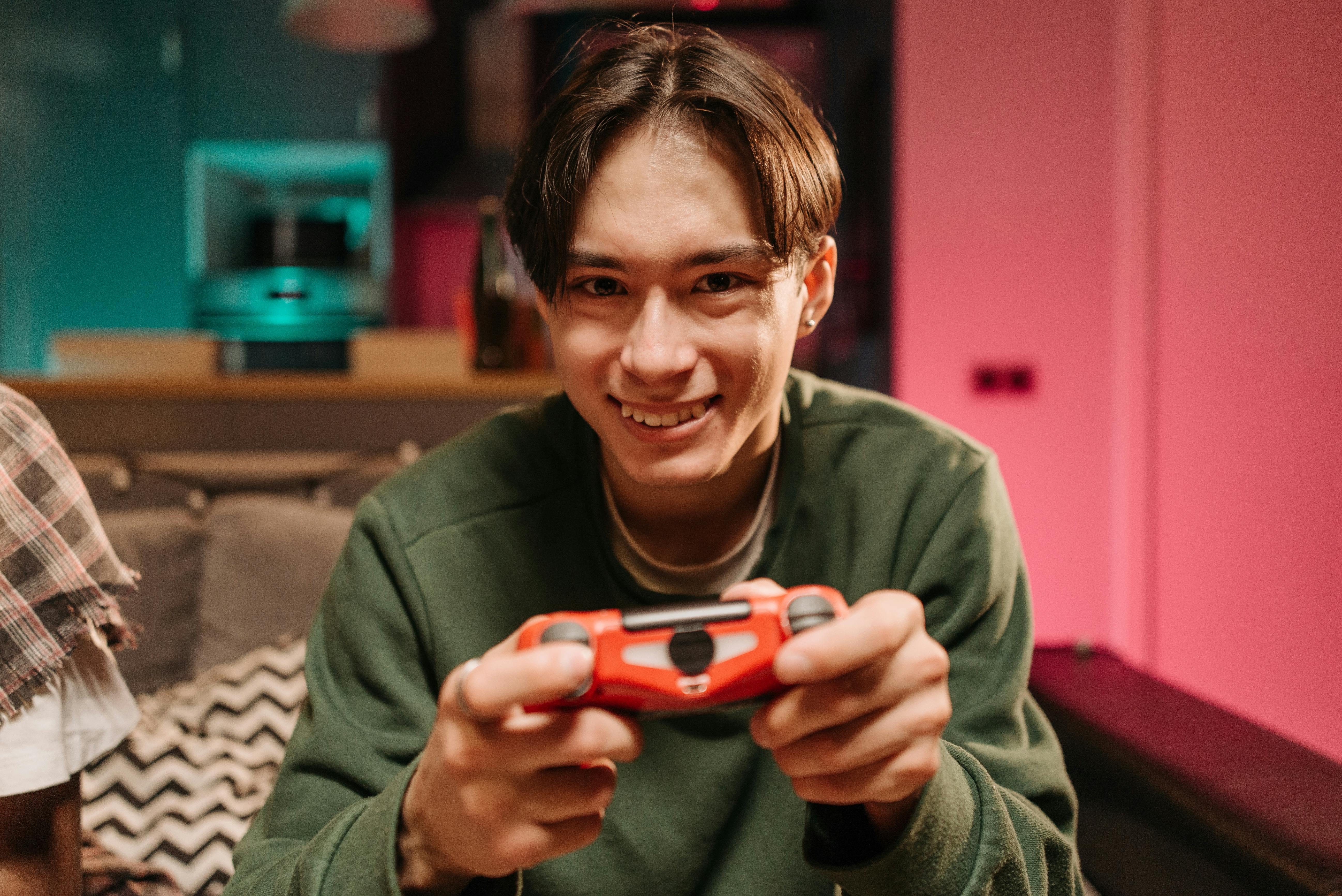 A Smiling Man Playing a Video Game · Free Stock Photo