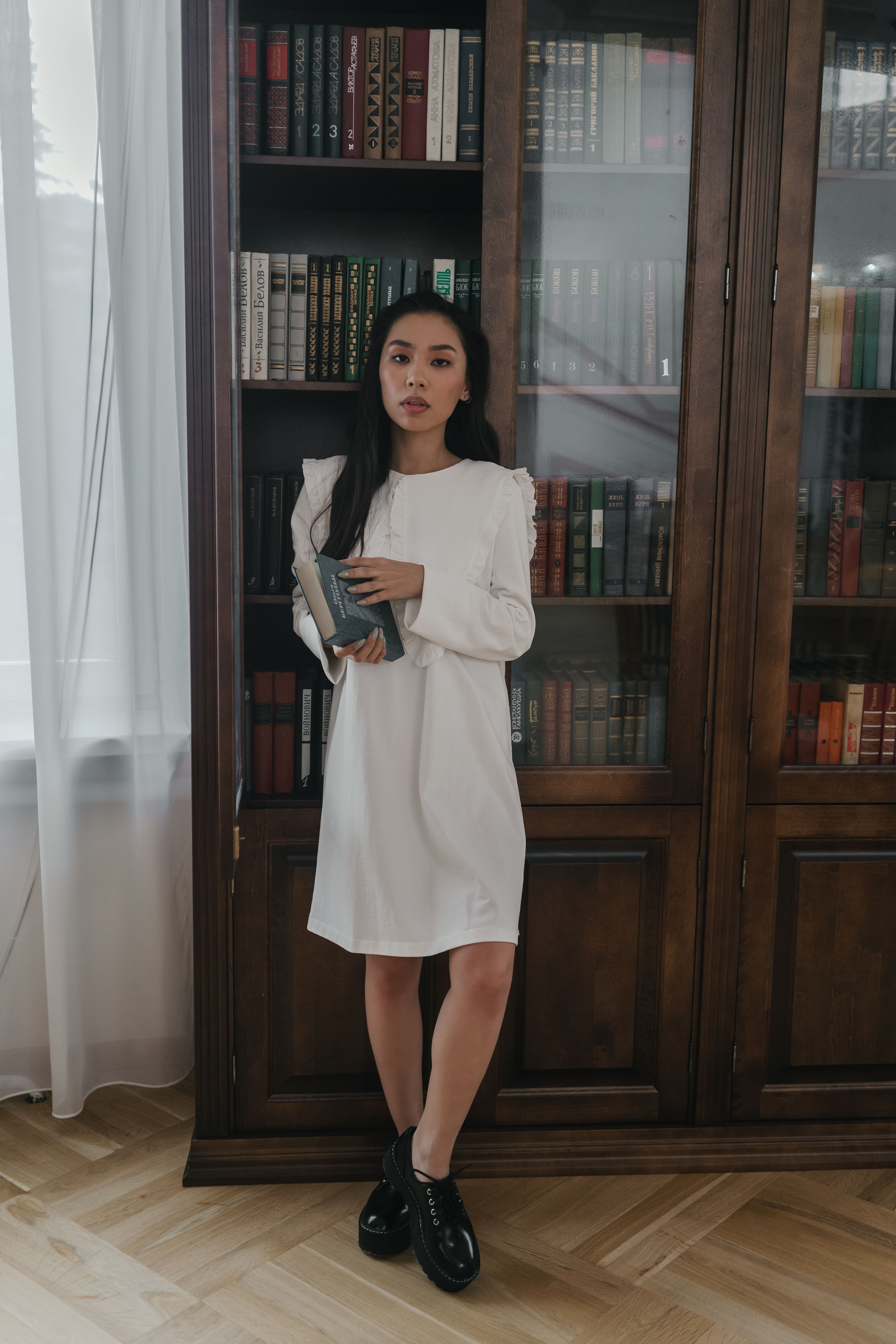 A Stylish Woman Posing in front of a Bookcase · Free Stock Photo