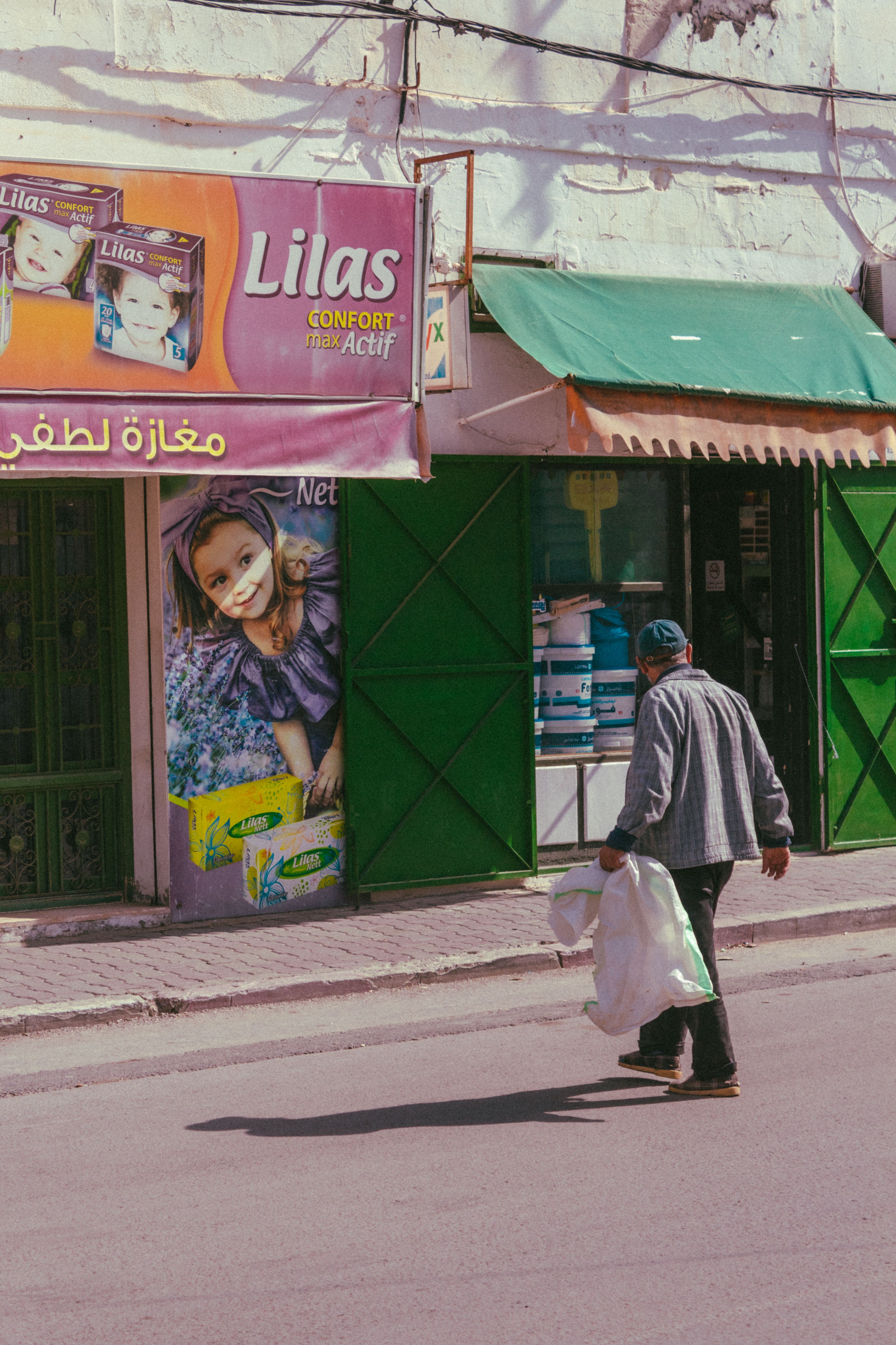 Photo of a Man Walking Near a Store · Free Stock Photo