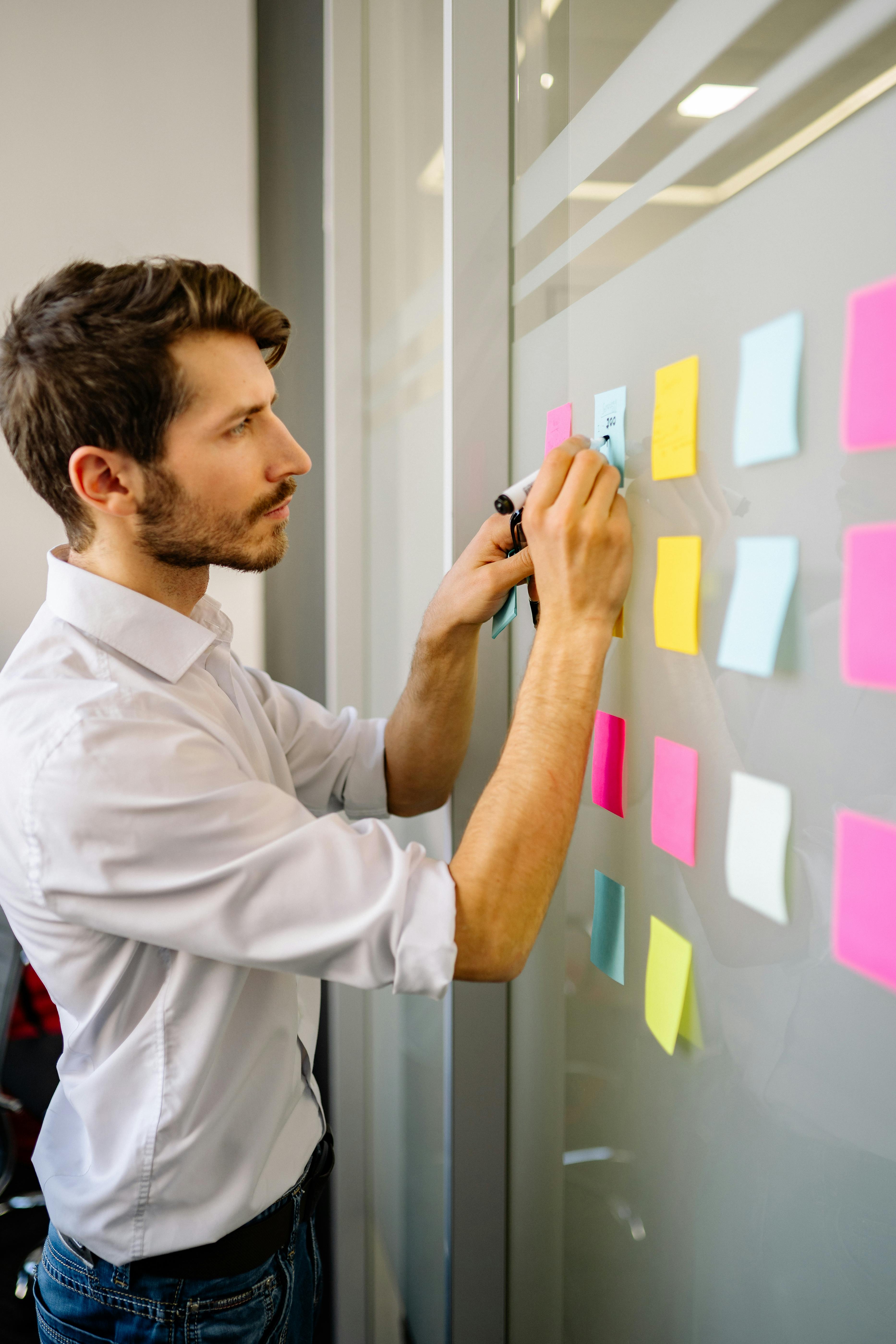 A Man Posting a Schedule Reminder · Free Stock Photo