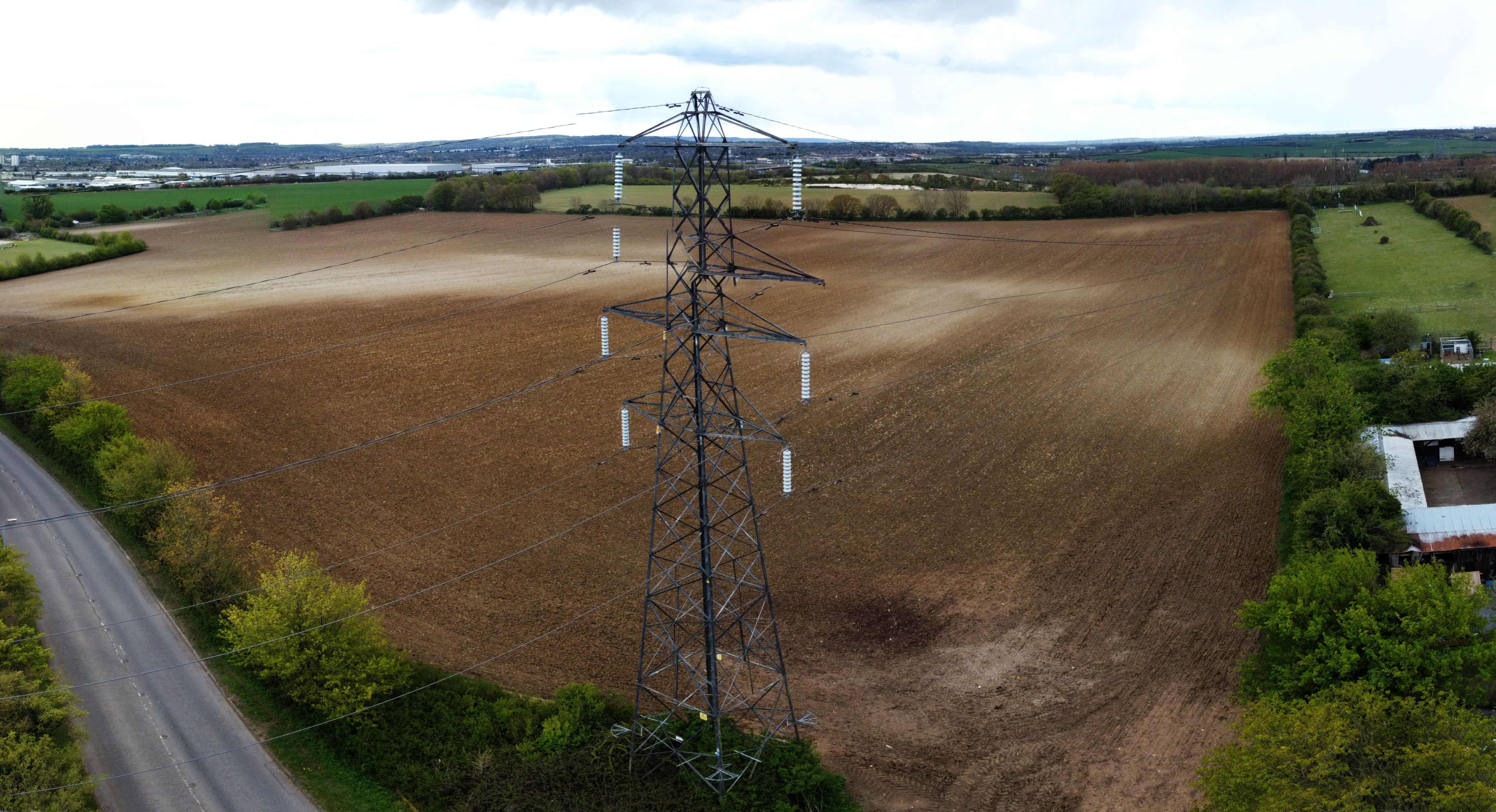 Power Transmission Tower and Lines on a Brown Field · Free Stock Photo