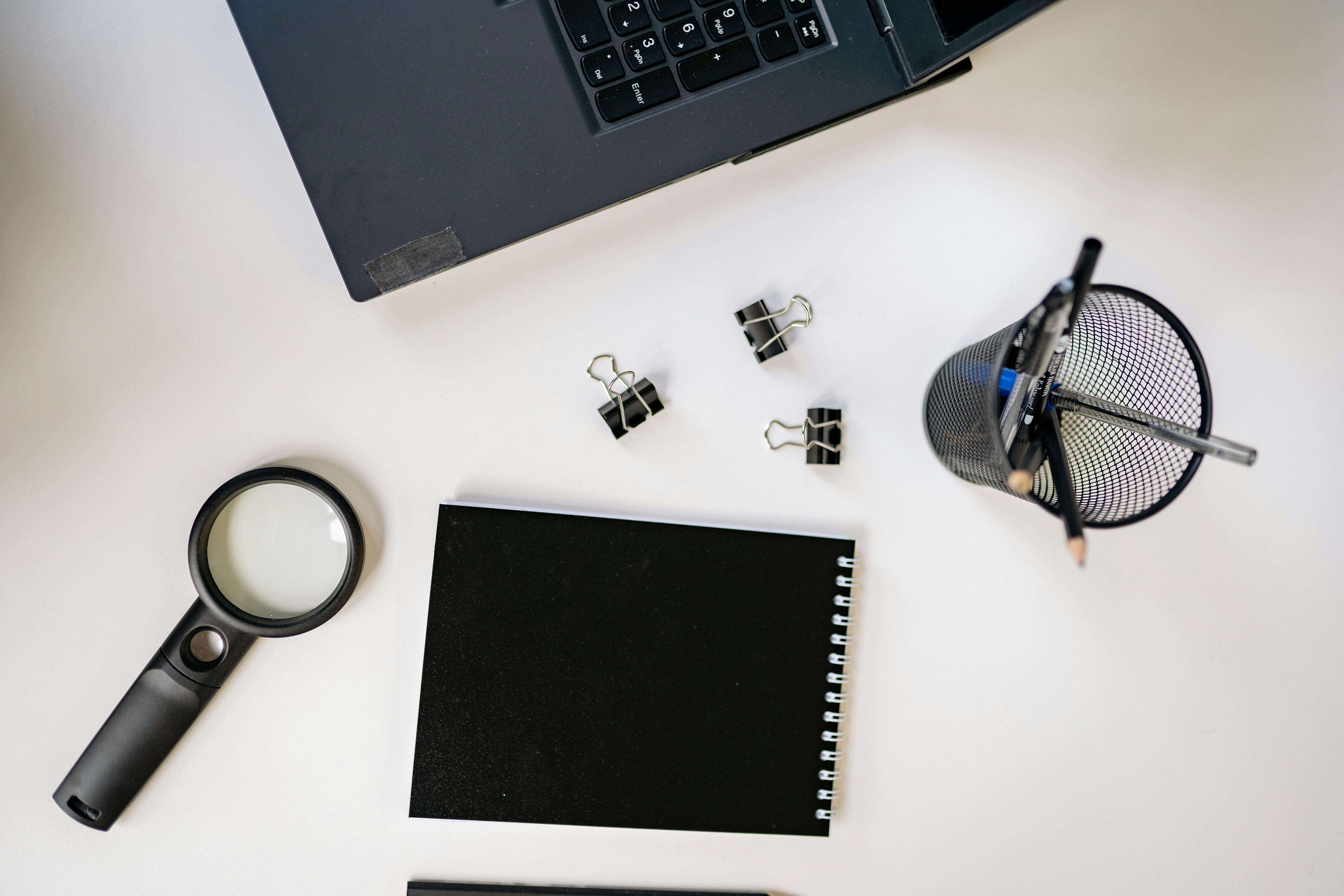 Gold Colored Paper Clips Near Notebook And Pen On White Surface · Free ...