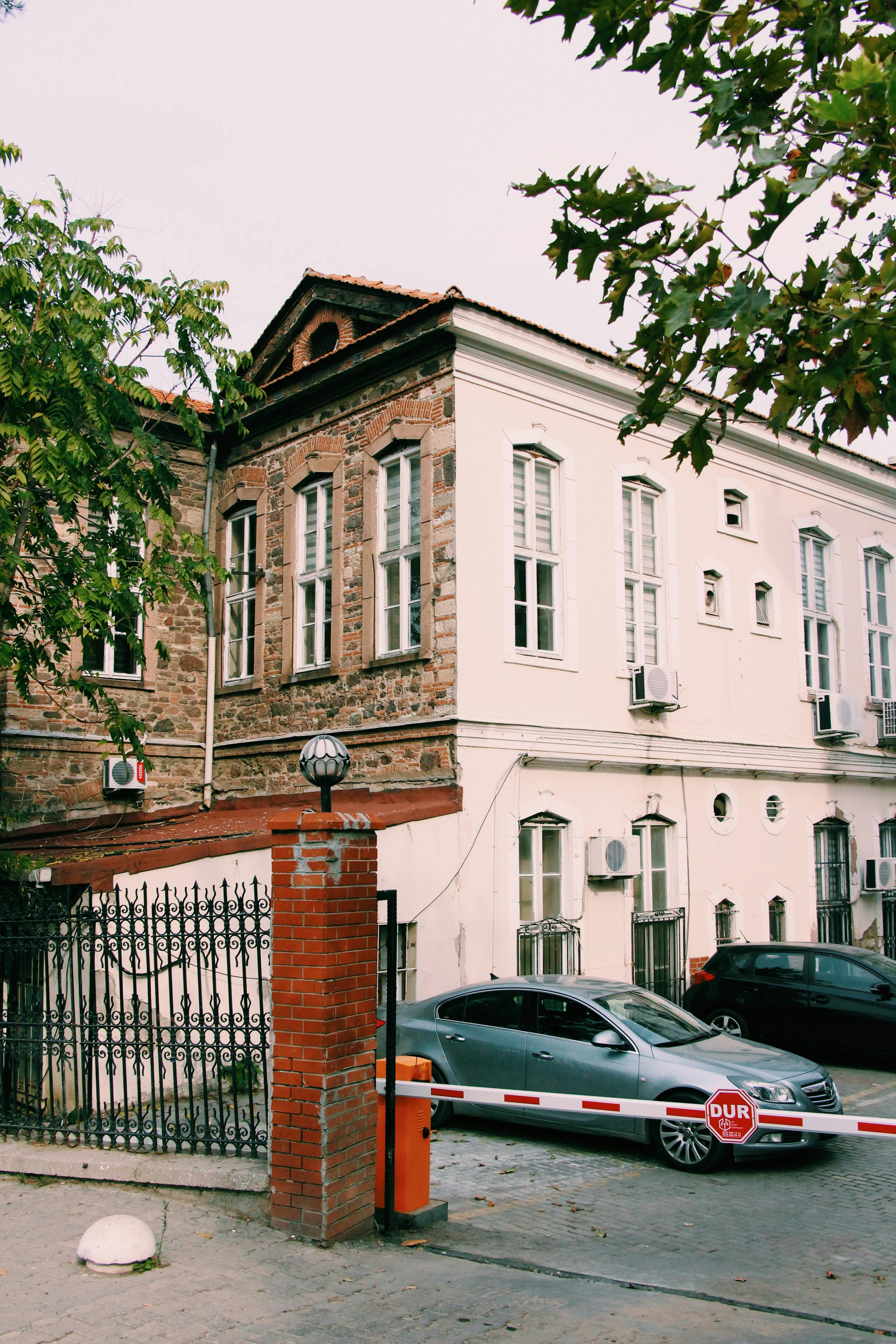 Man Walking Between a Concrete Fence and Metal Railings of a Building ...