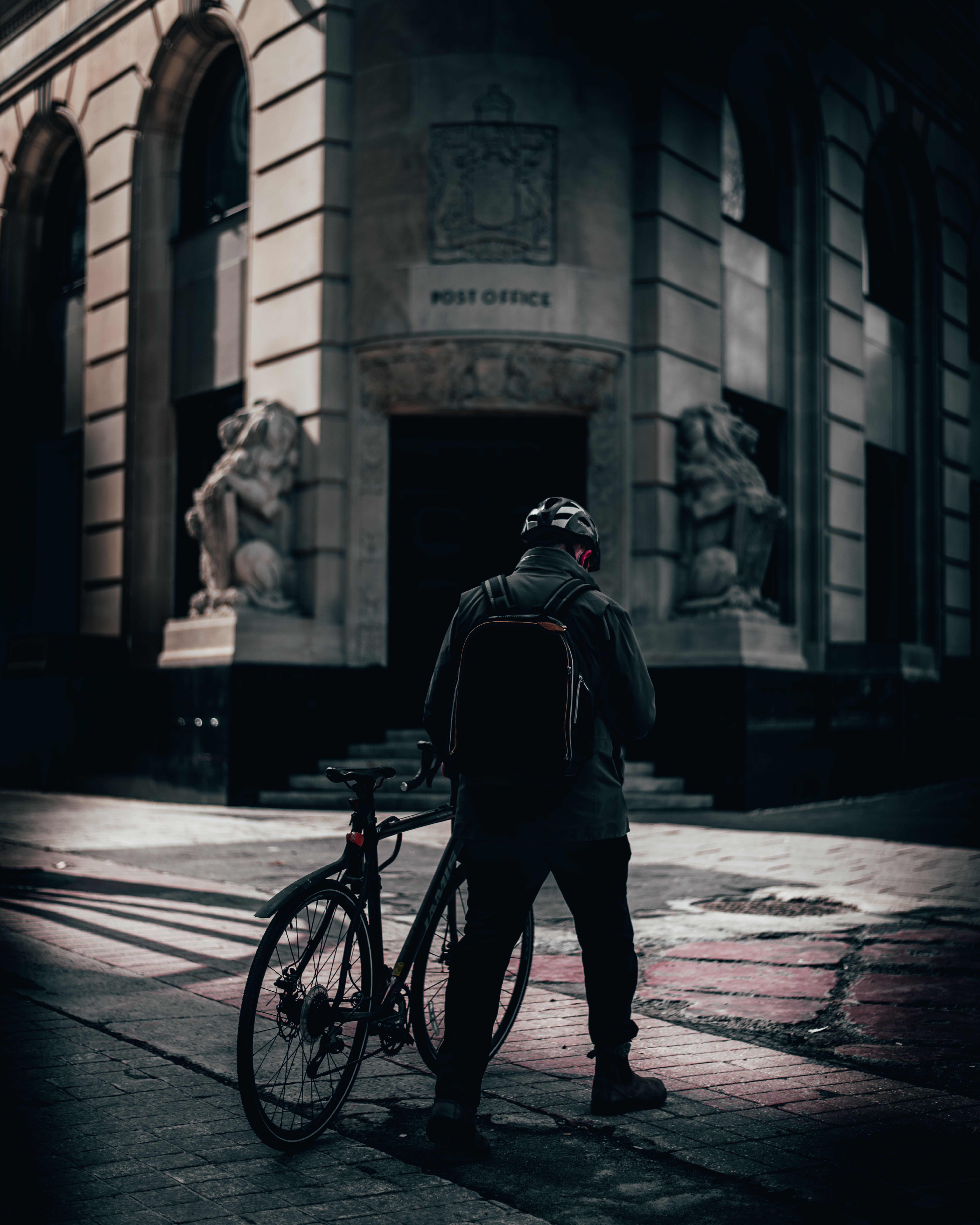 A Man with a Bike Standing in Front of the Post Office Building · Free ...