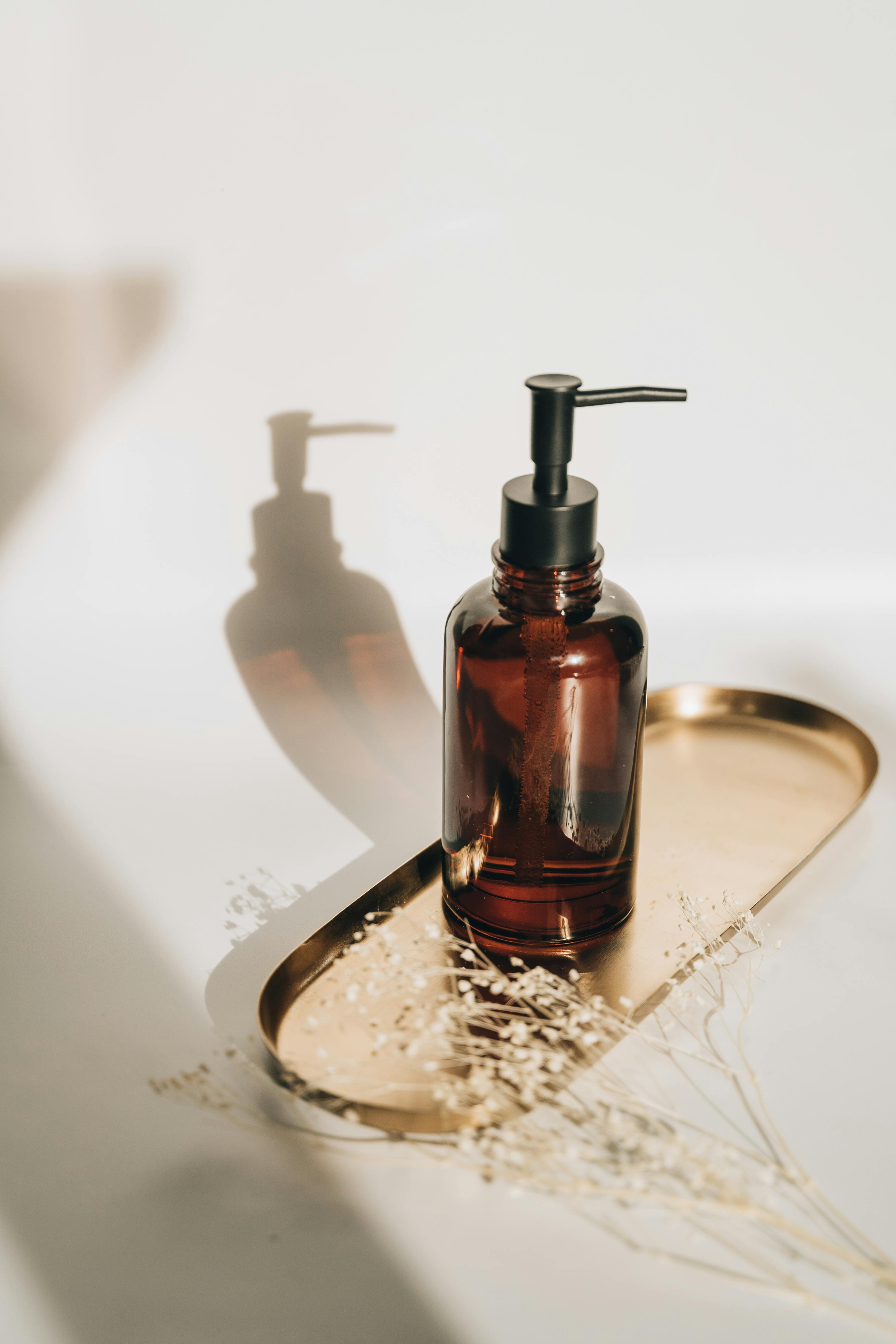 Brown Pump Glass Bottle on a Steel Tray · Free Stock Photo