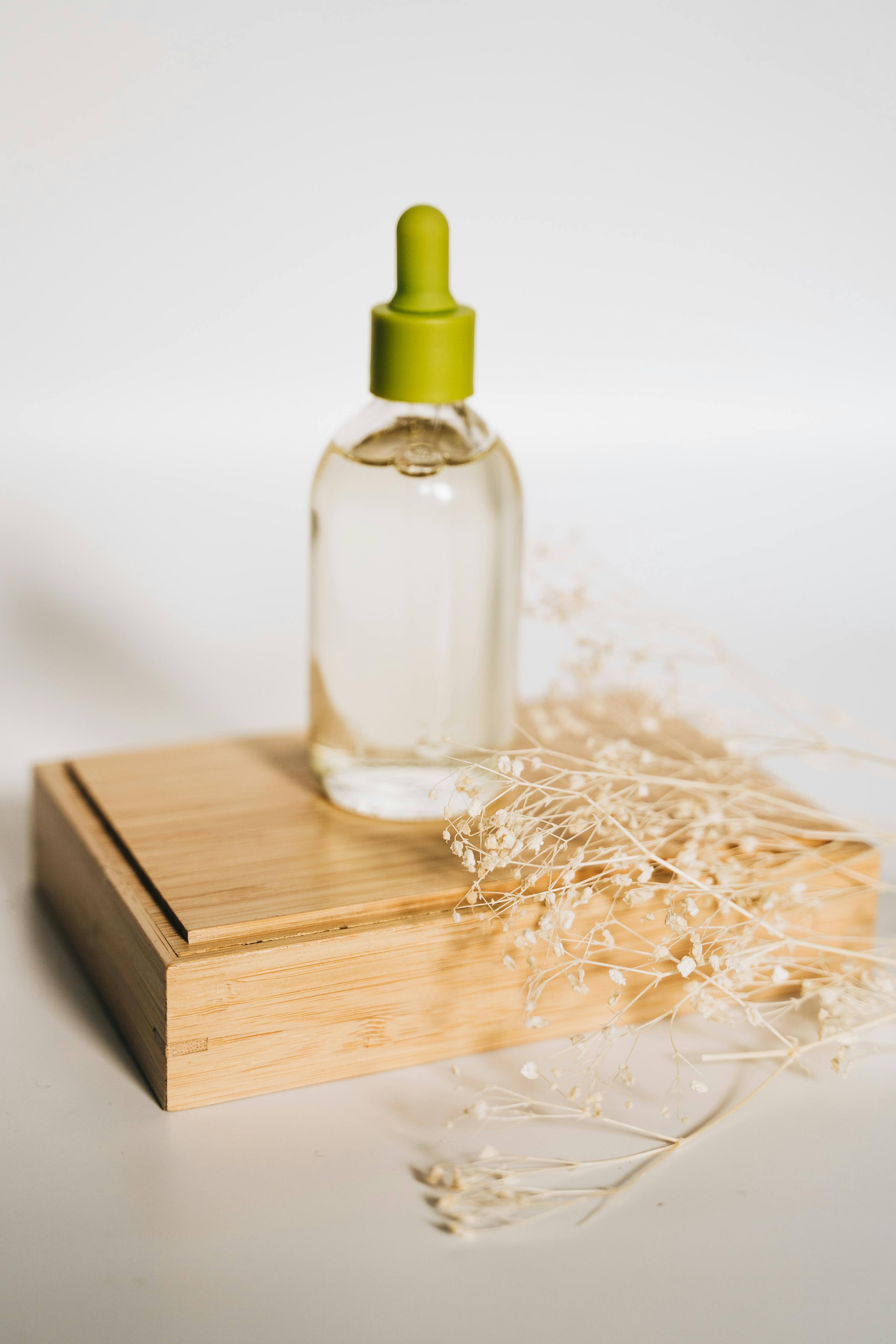 Clear Serum Bottle on Top of a Wooden Box · Free Stock Photo