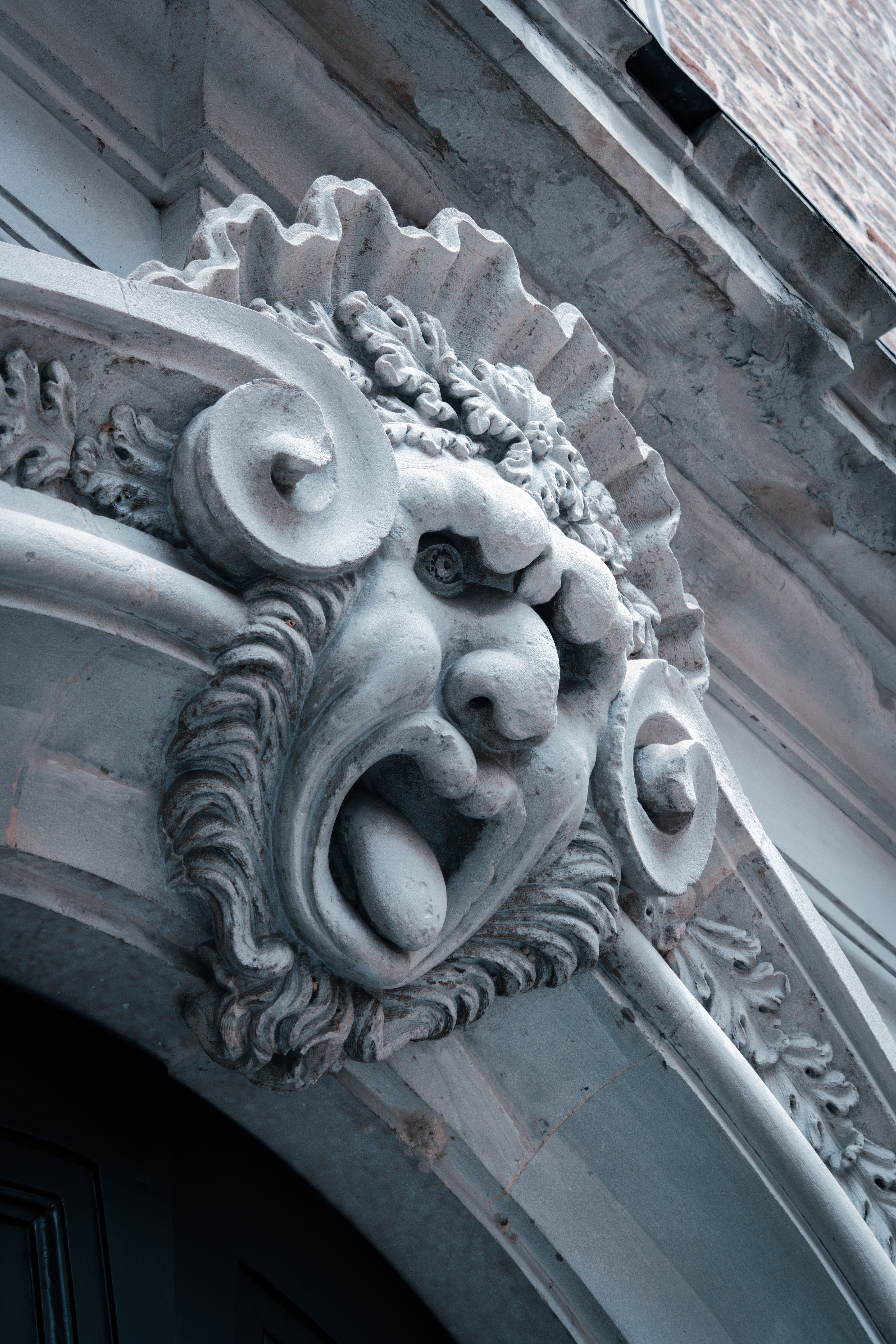 Close Up of Carved Scary Face on Building Facade · Free Stock Photo