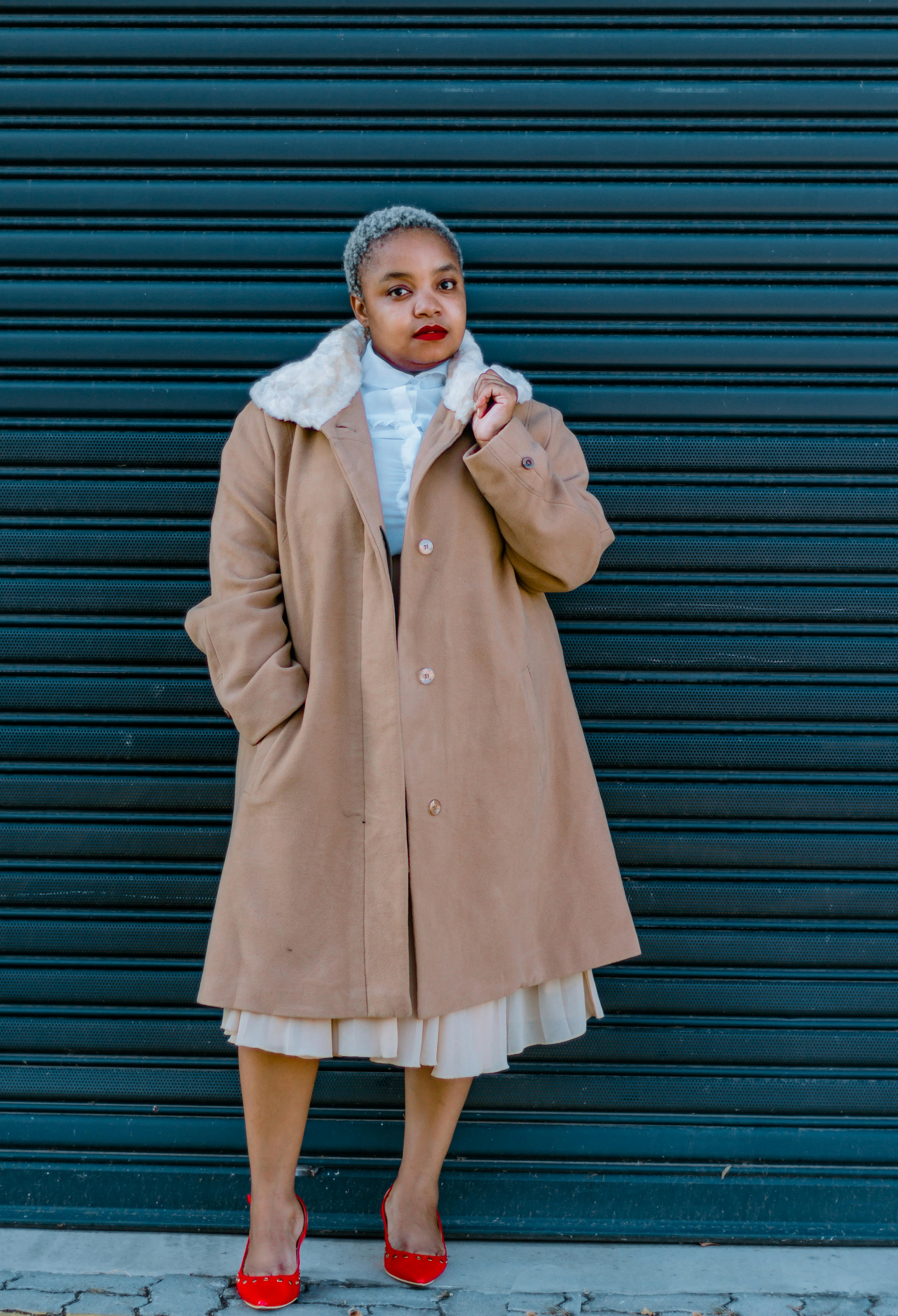 Man in a Brown Coat and a Beanie Standing against the Wall · Free Stock ...