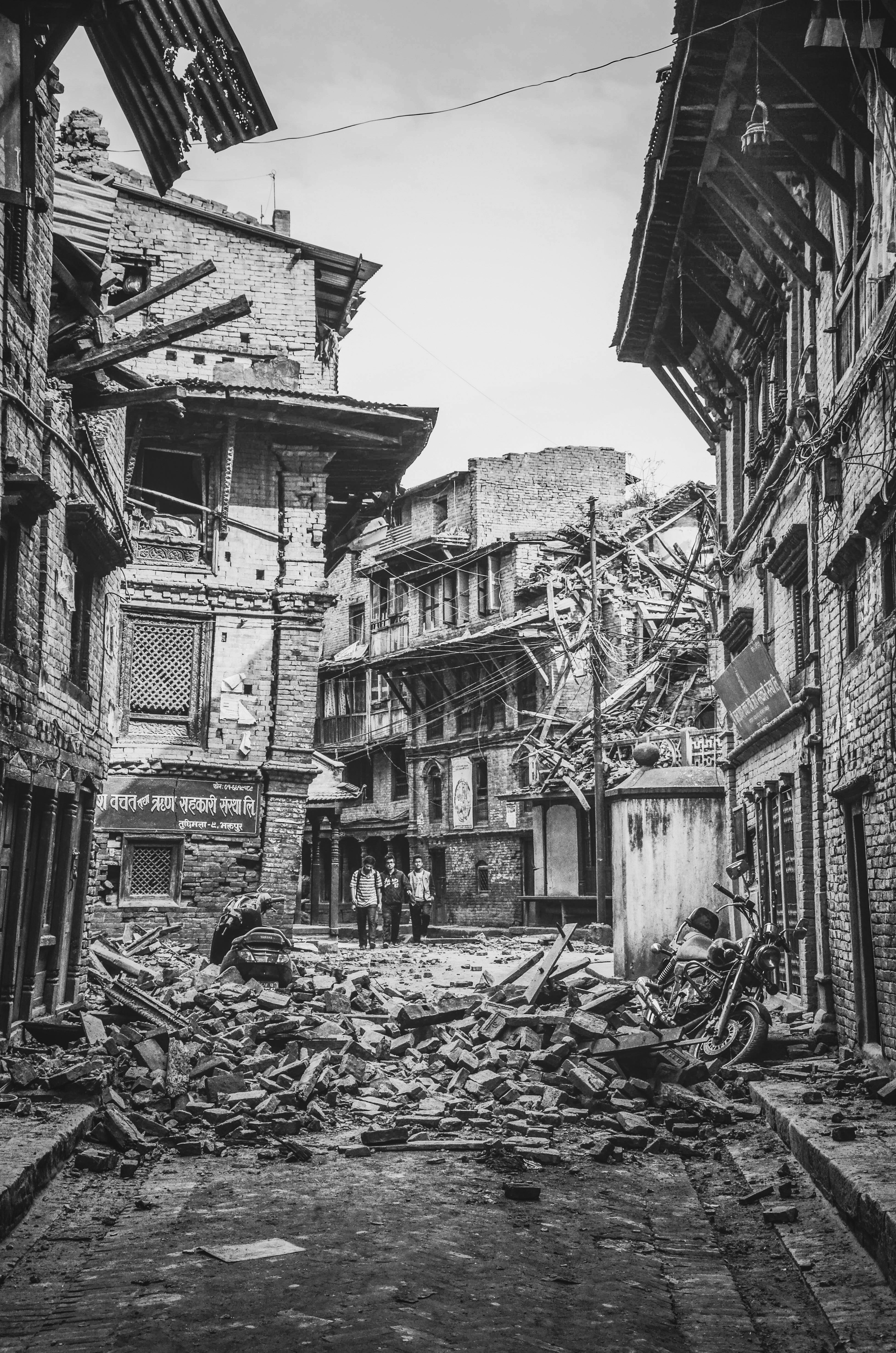 People Walking Near Wrecked Buildings · Free Stock Photo