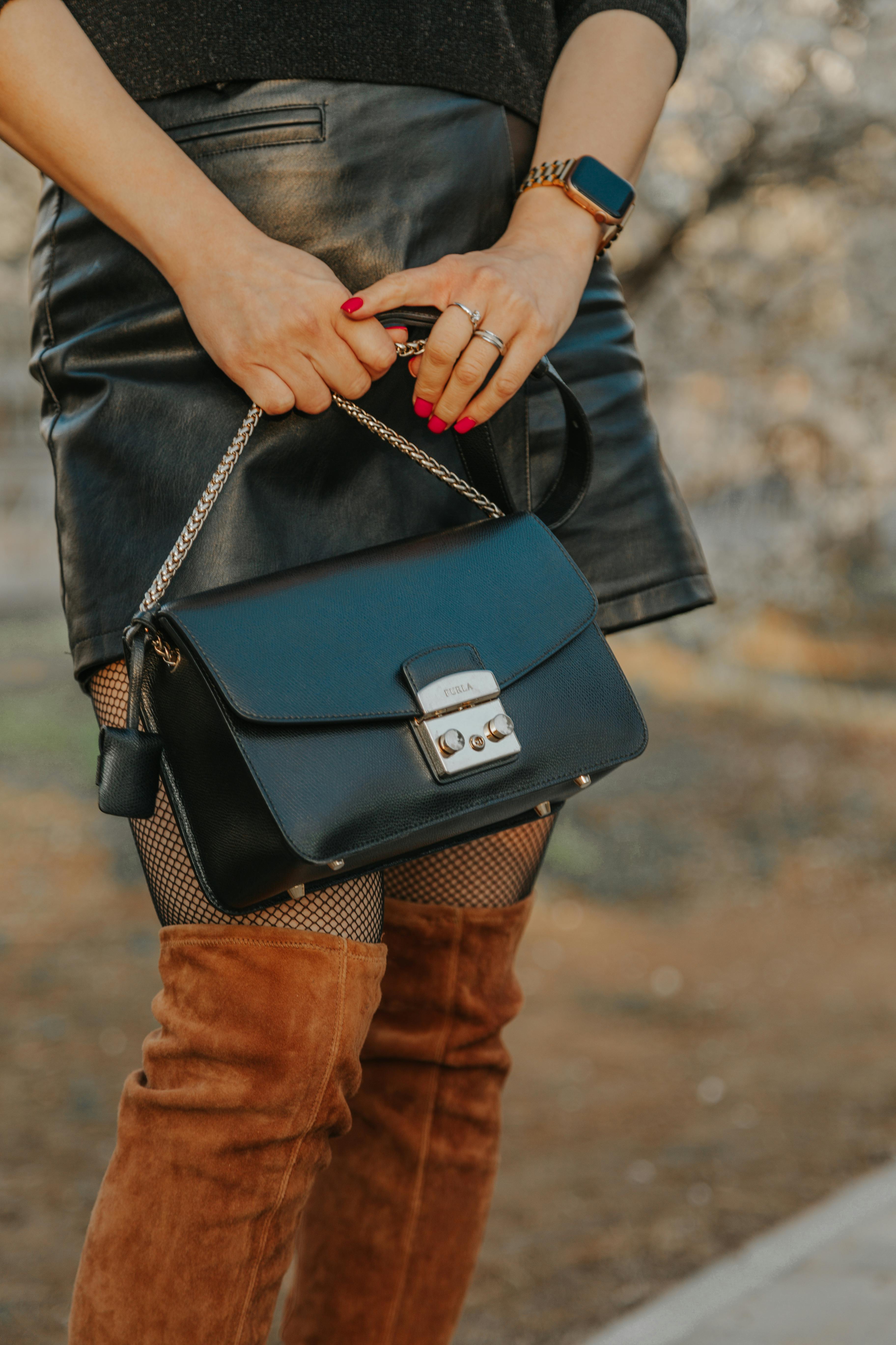 Close-Up View of a Person Holding a Black Shoulder Bag · Free Stock Photo