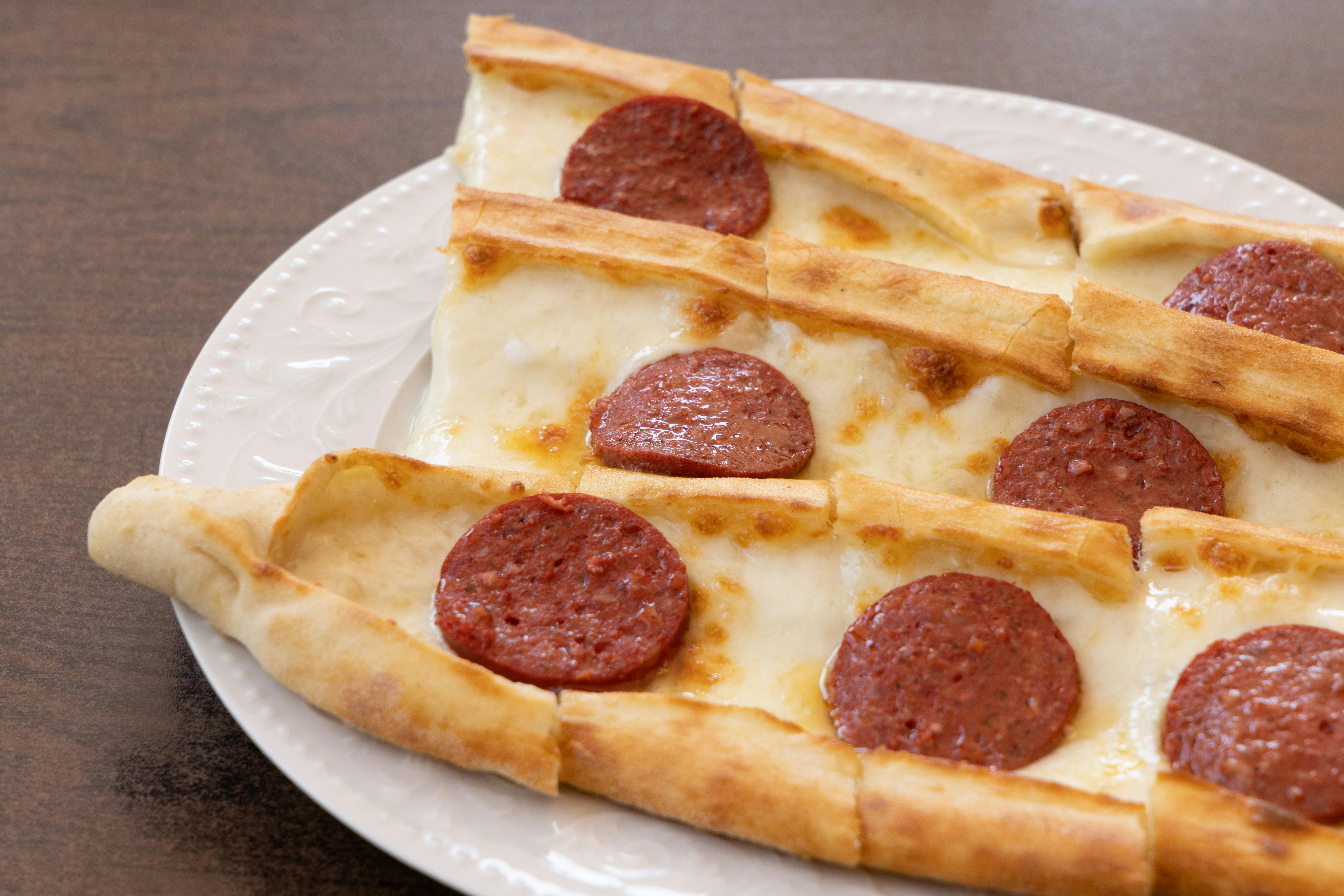 Slices of Cheese Pide with Pepperoni Toppings on a White Ceramic Plate ...