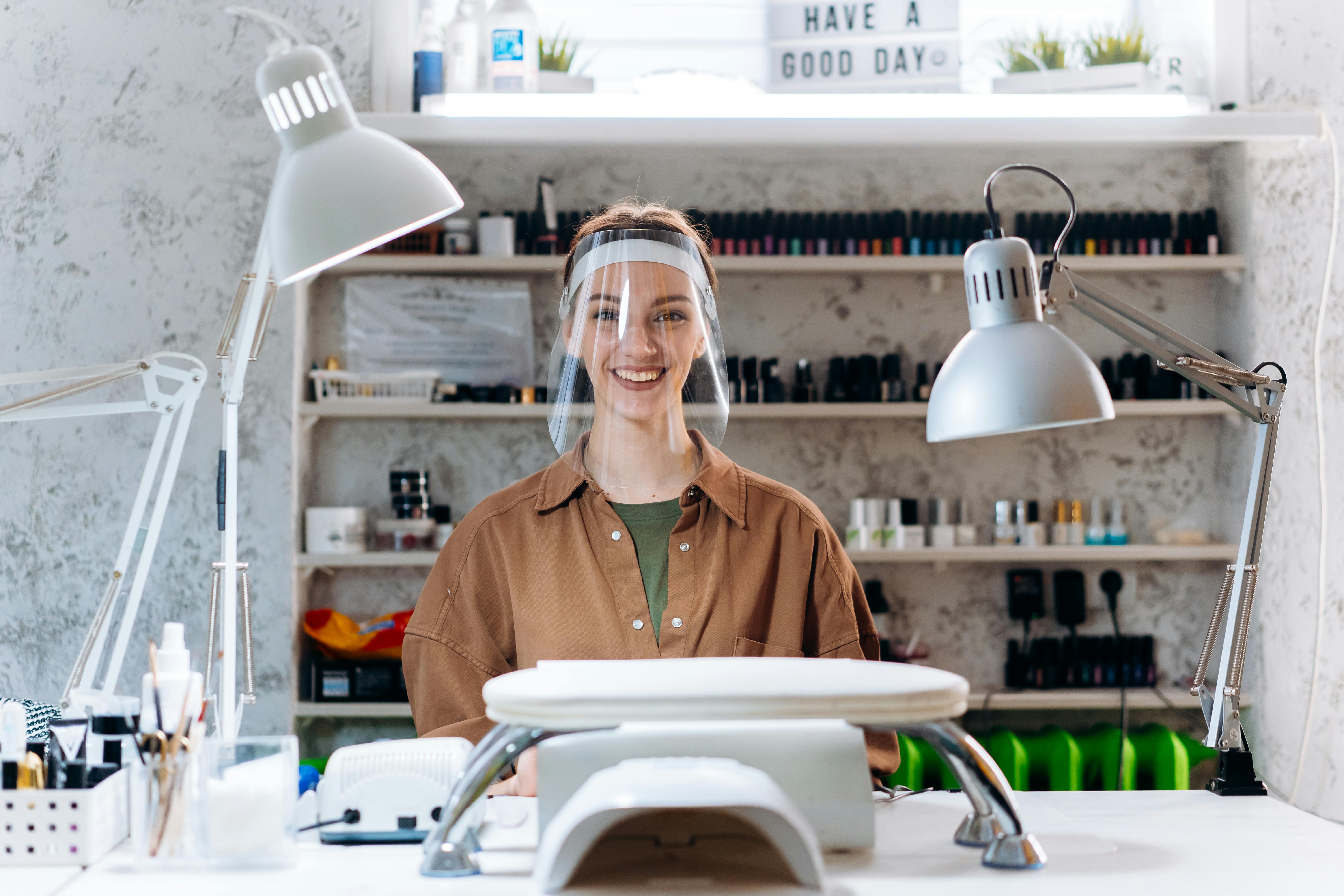 A Happy Woman Wearing a Face Shield at a Nail Salon · Free Stock Photo