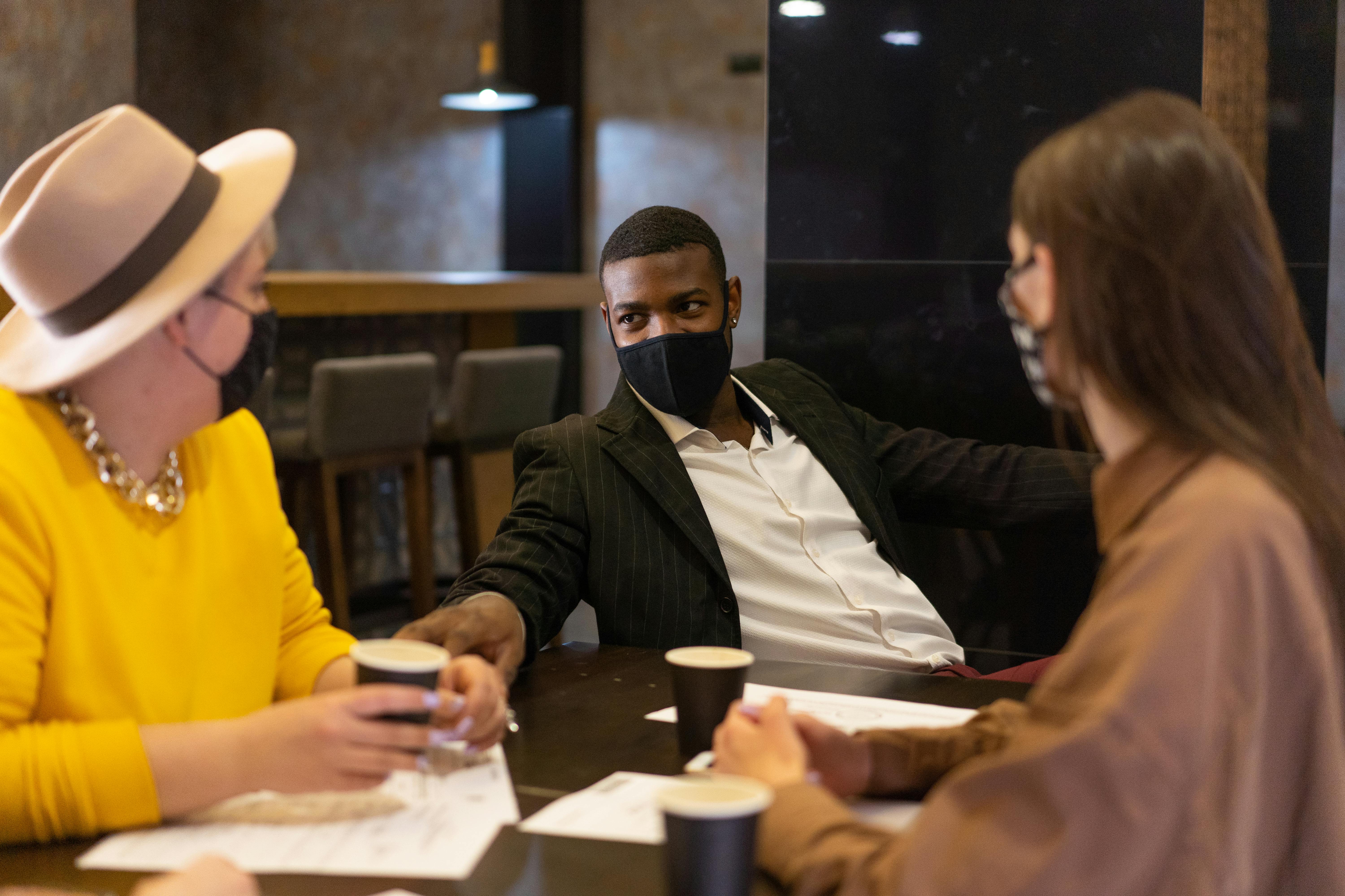 People Sitting at Table Wearing Face Masks · Free Stock Photo